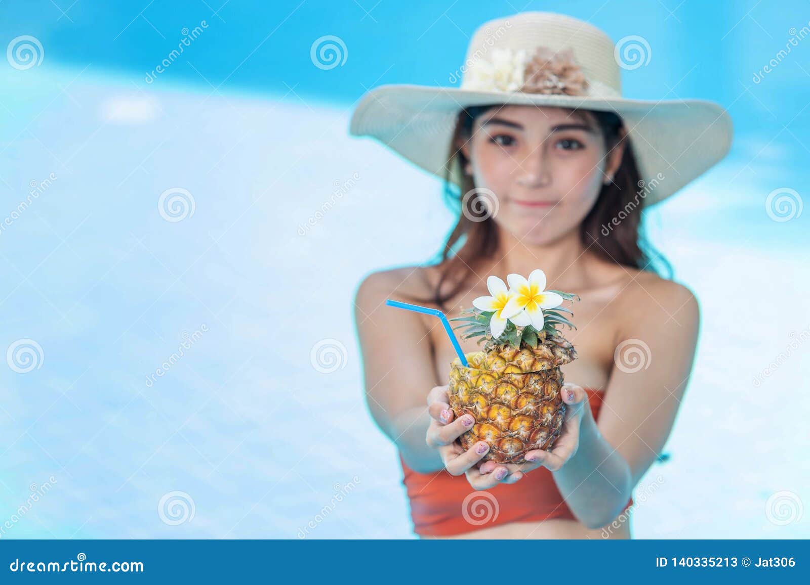 Beautiful Female In Bikini Relaxing At The Pool And Holding Pineapple