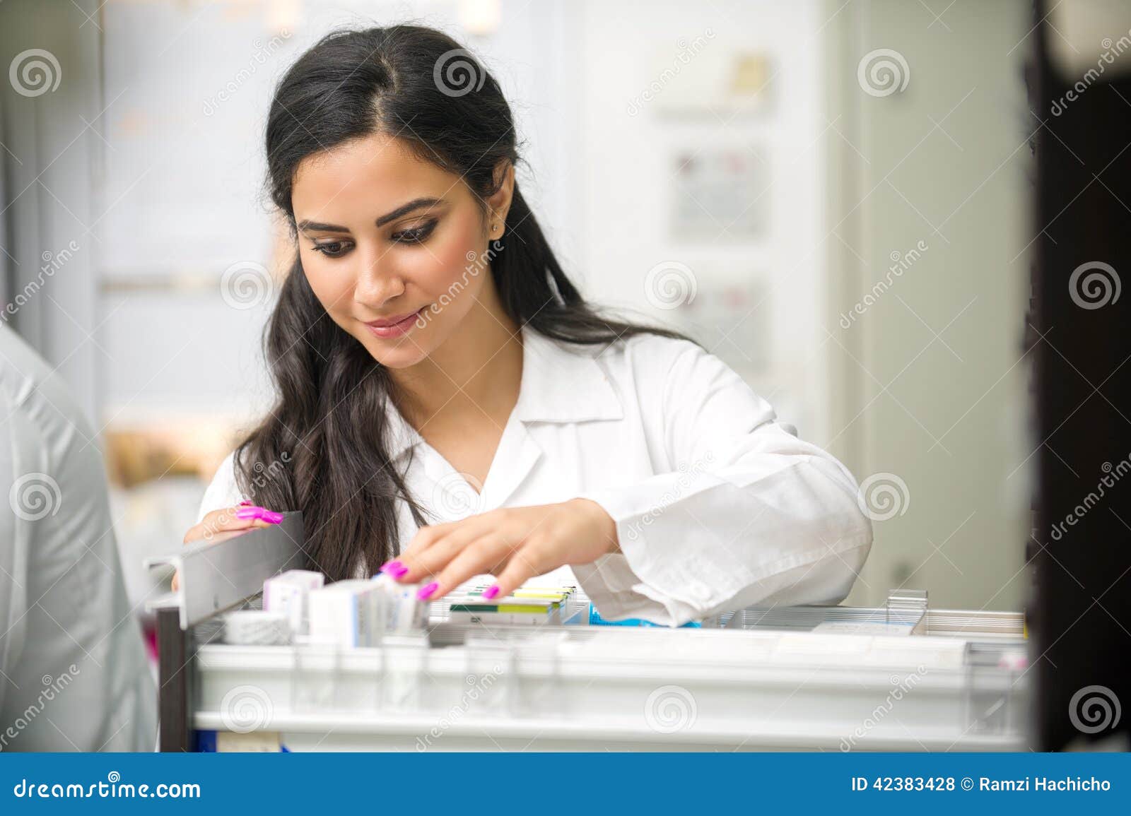 Beautiful Female Pharmacist Looking at Medicine Stock Photo - Image of ...