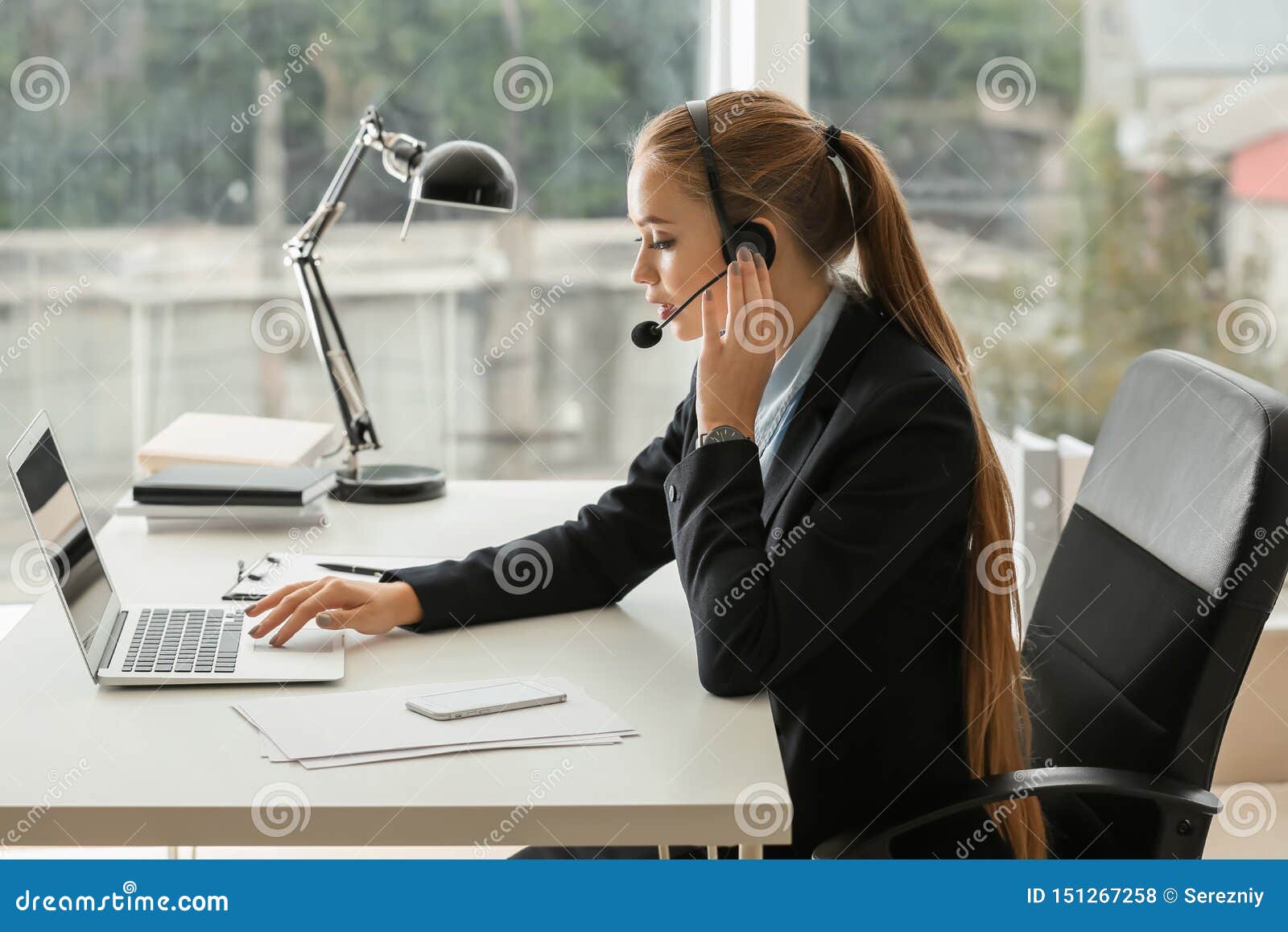 Beautiful Female Secretary Talking through Headset in Office Stock ...
