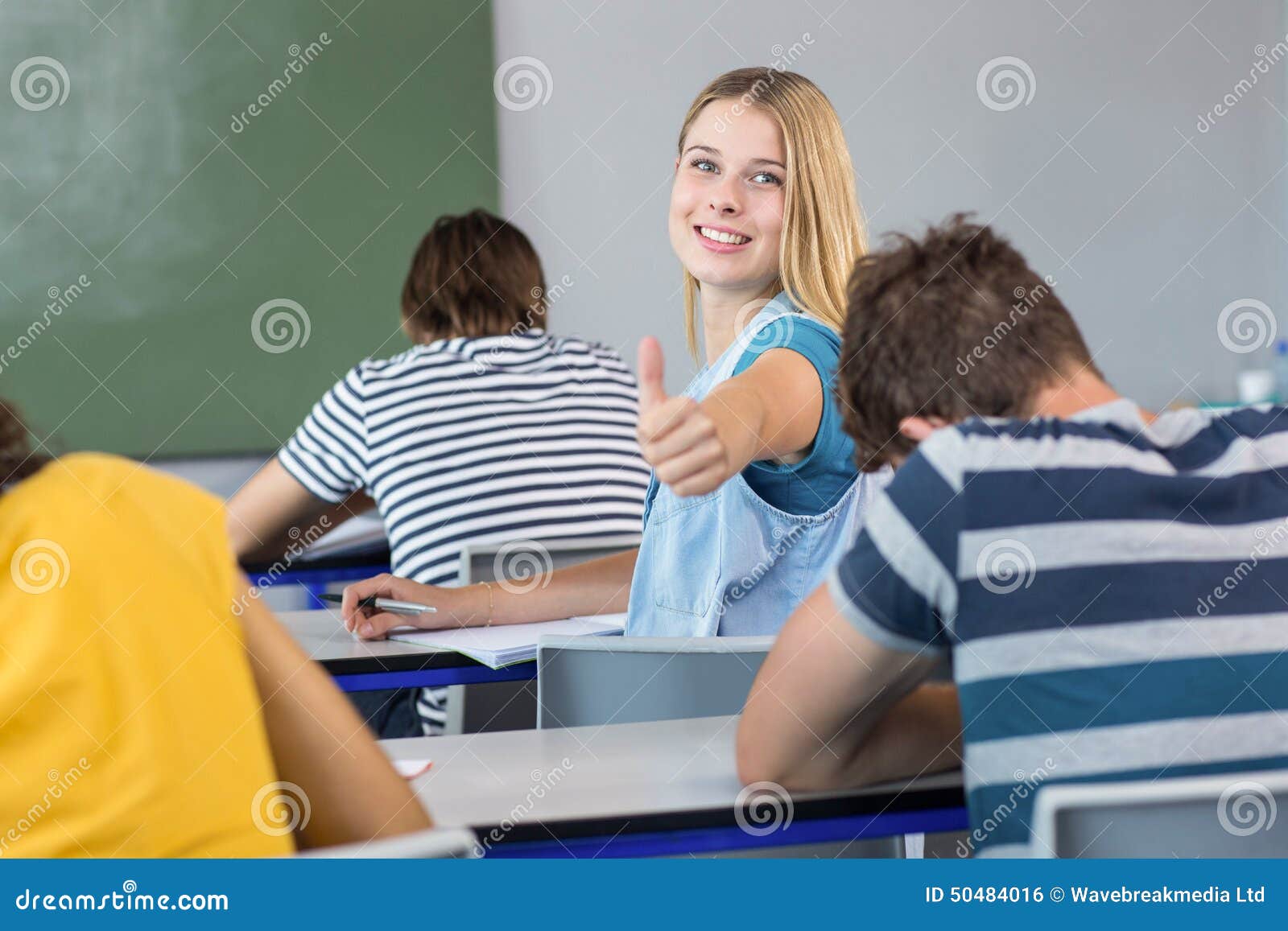 Beautiful Female Student Gesturing Thumbs Up in Class Stock Photo ...