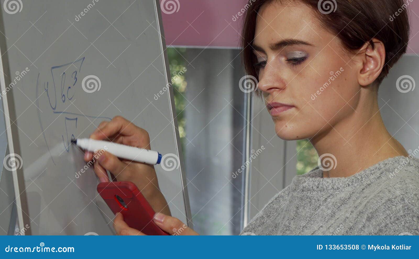 Beautiful Female Student Using Her Smart Phone while Solving Math ...