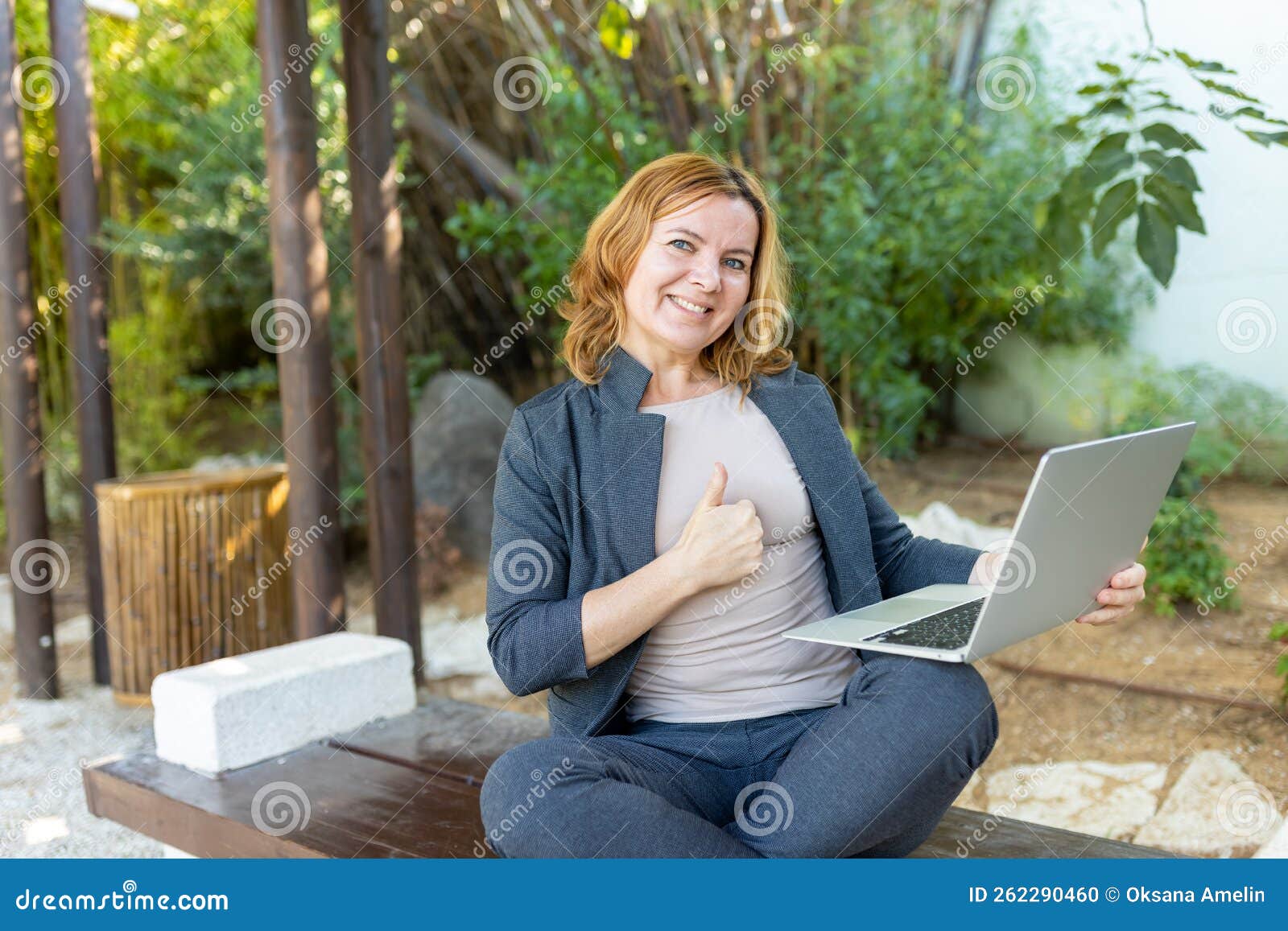 A Beautiful Freelancer Woman Works at the Park Using a Computer Stock ...