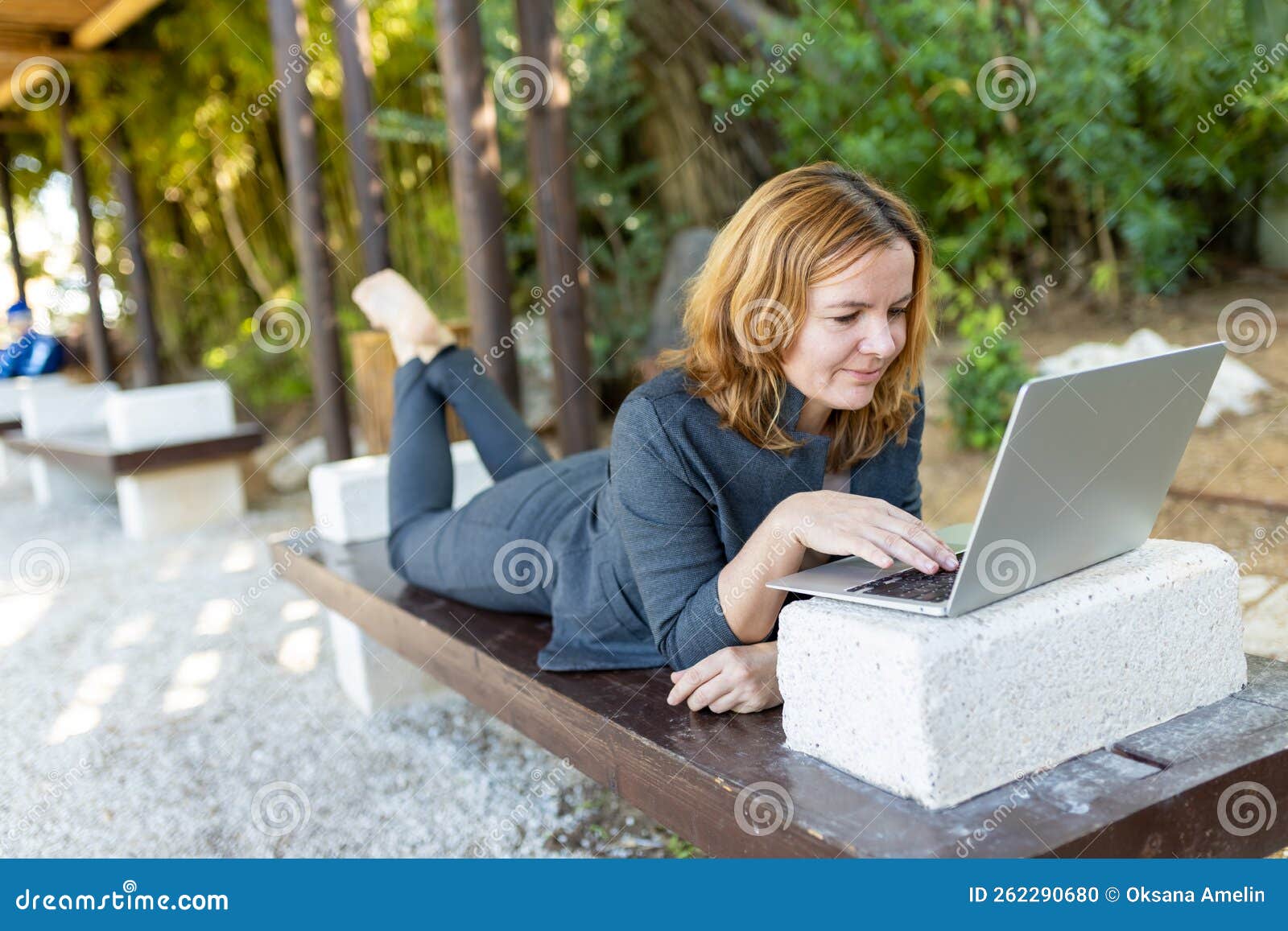 A Beautiful Freelancer Woman Works at the Park Using a Computer Stock ...