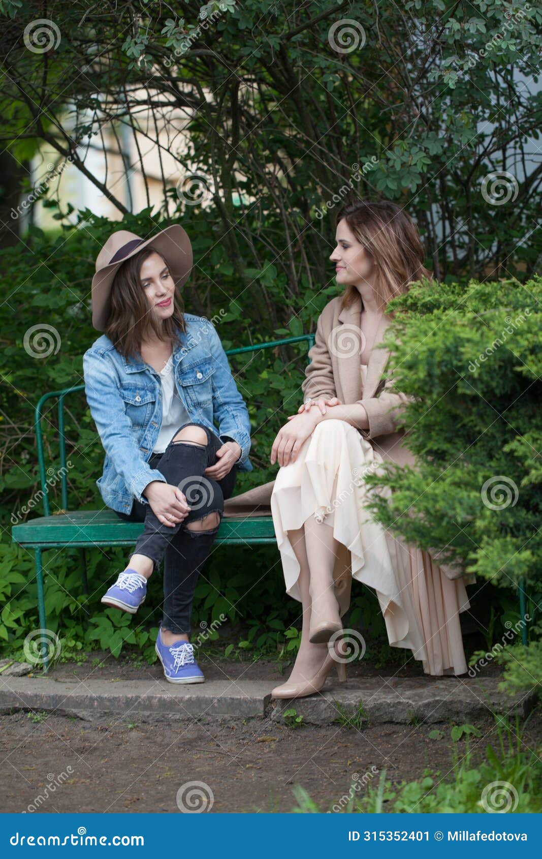 Beautiful Friends Talking and Sitting on a Park Bench Outdoors Stock ...