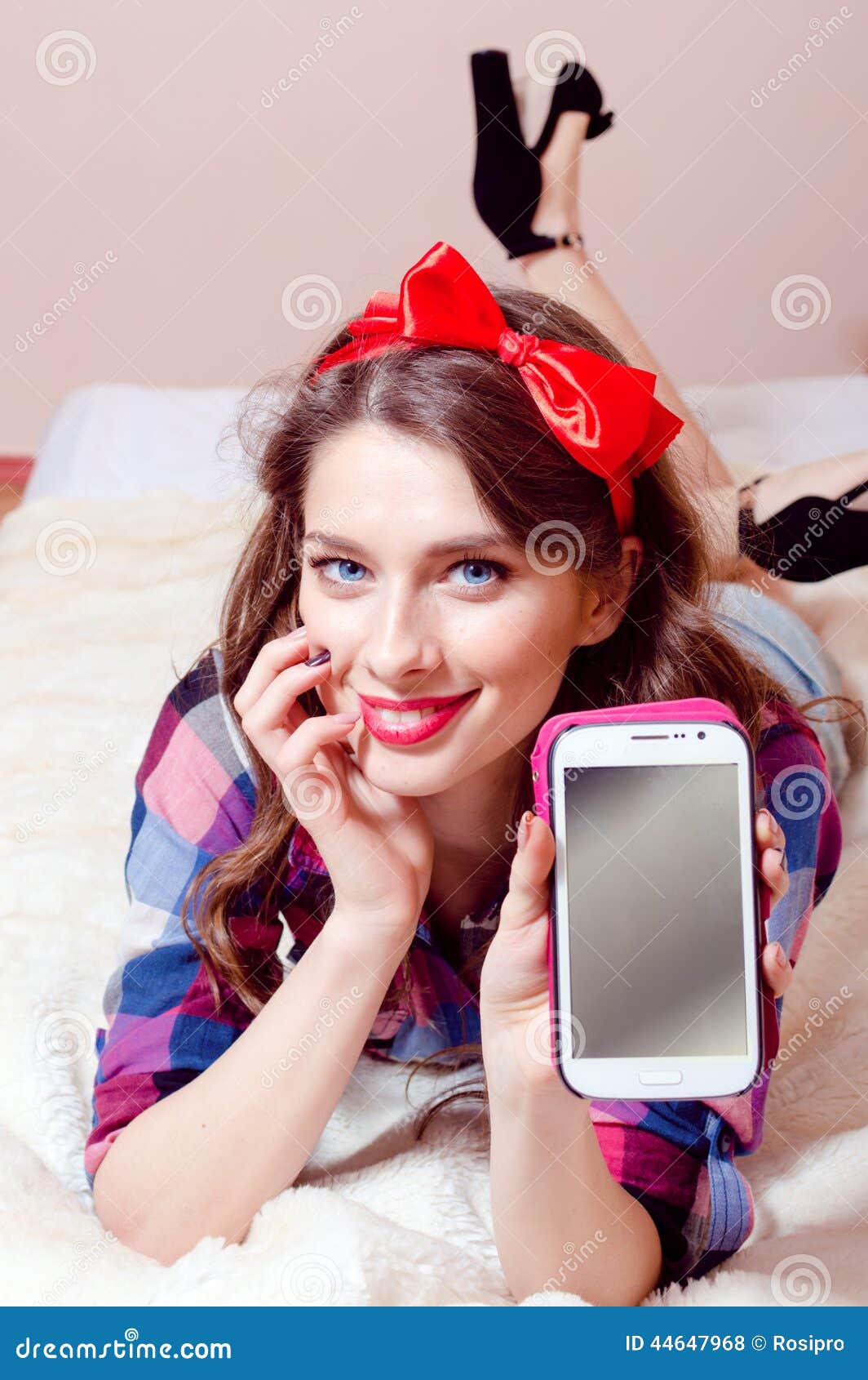 Beautiful Funny Pinup Girl Relaxing Lying In Bed Showing Mobile Phone Display Happy Smiling