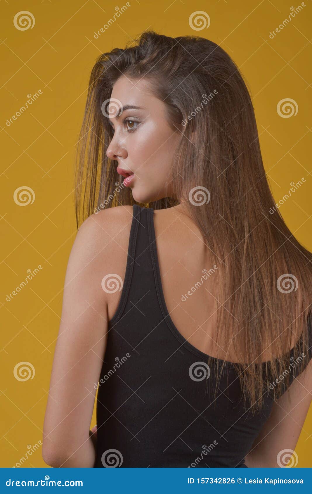 Beautiful Girl In A Black Bodysuit Posing On Yellow Background Stock