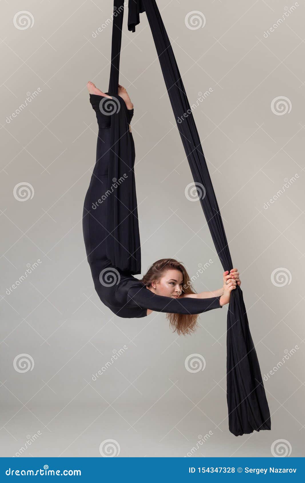 Beautiful Girl in a Black Sport Suit is Performing an Acrobatic ...