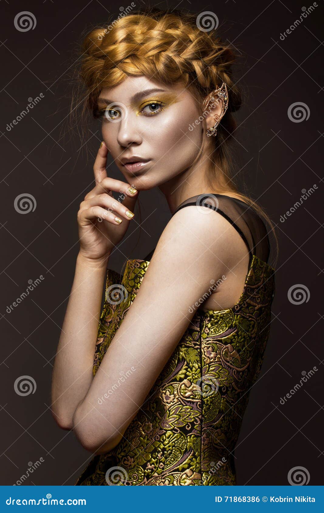 Beautiful Girl In A Gold Dress With Creative Makeup And Braids On Her