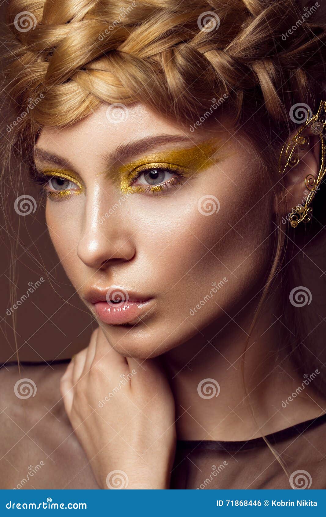 Beautiful Girl In A Gold Dress With Creative Makeup And Braids On Her