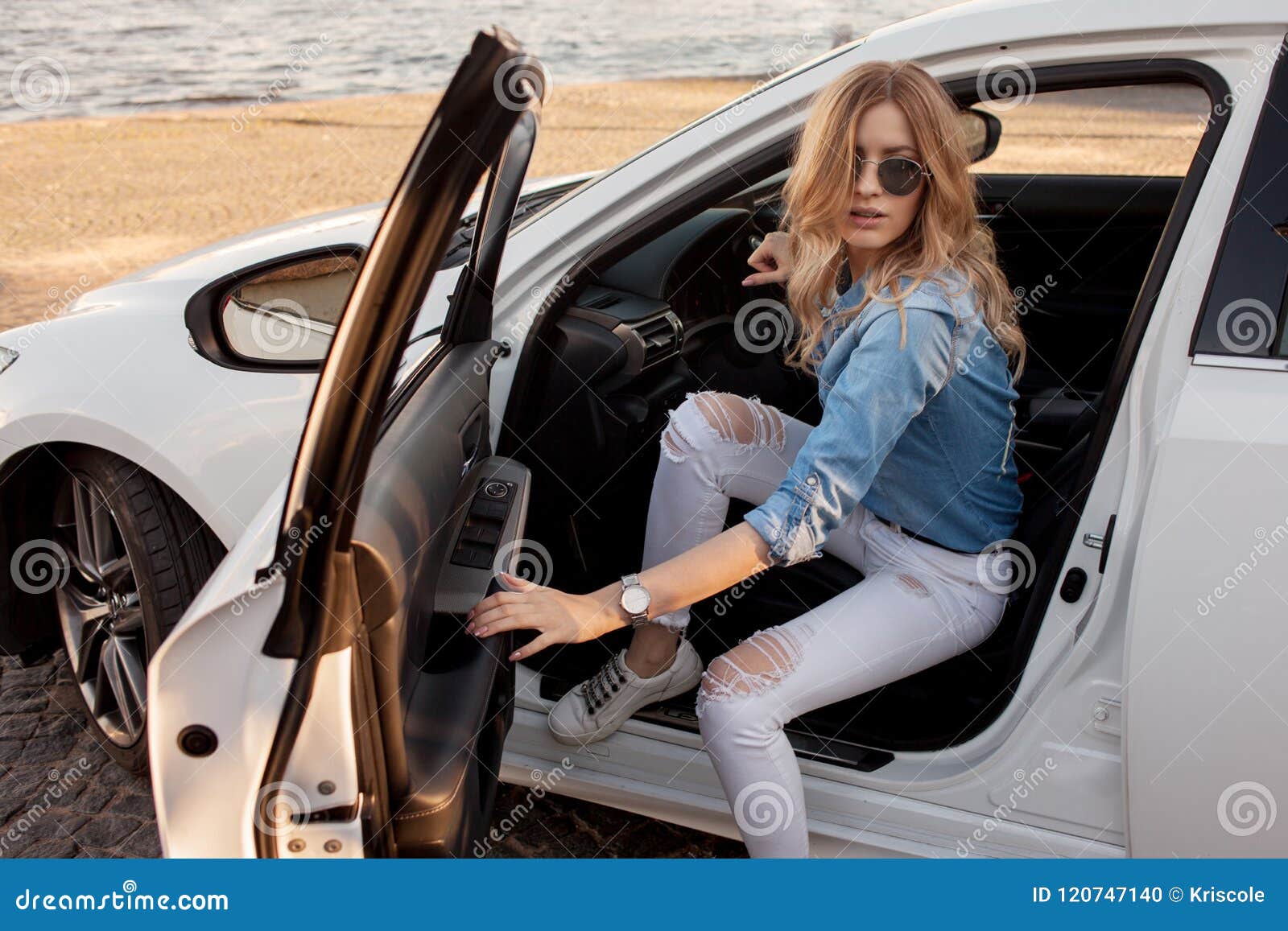 Beautiful Girl In Jeans Climbs Out Of The Car Portrait Of A Successful