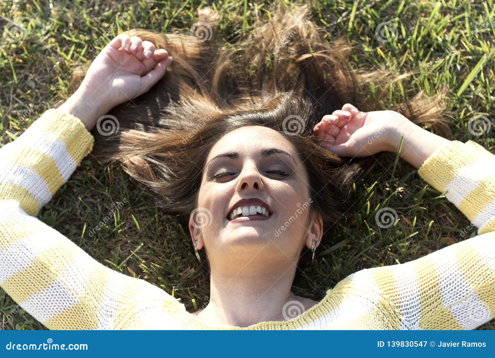 Beautiful Girl Lying On Her Back On The Fresh Spring Grass In Spring