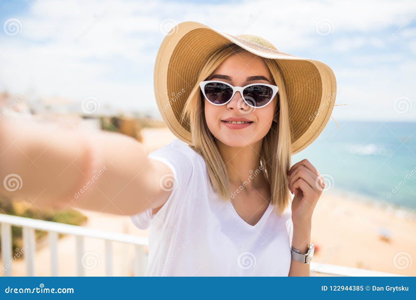 Beautiful Woman In Sunglasses And Summer Hat Taking Selfie On Beach