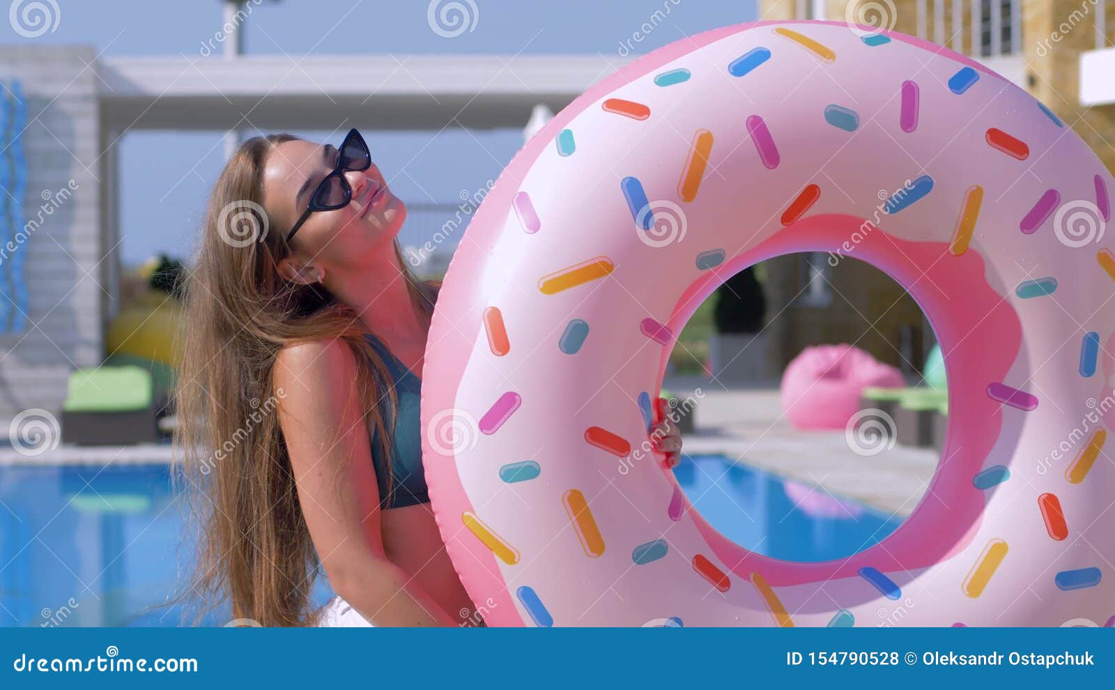 Beautiful Glamorous Girl Into Bathing Suit And Eyeglasses With Inflatable Rings Flirts On Camera