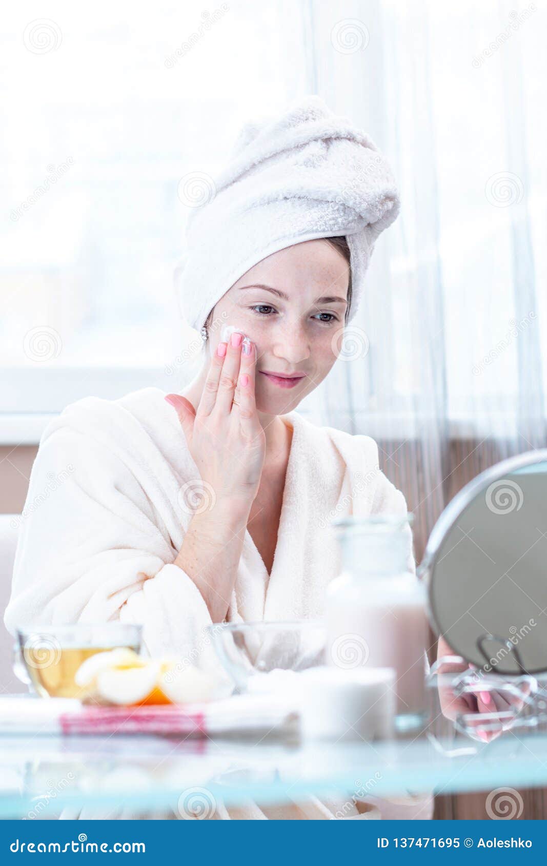 Beautiful Happy Young Woman Applying Cream On Face Moisturizing The