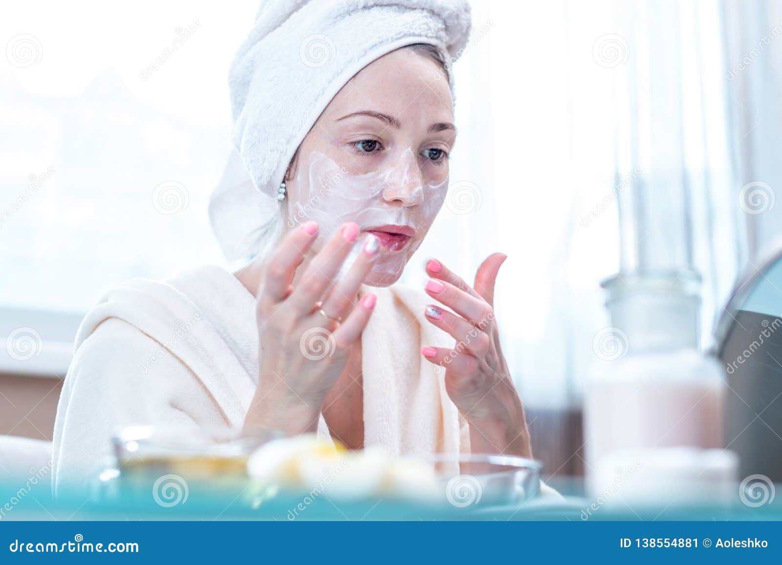 Beautiful Happy Woman Applying Cream On Face Moisturizing The Skin