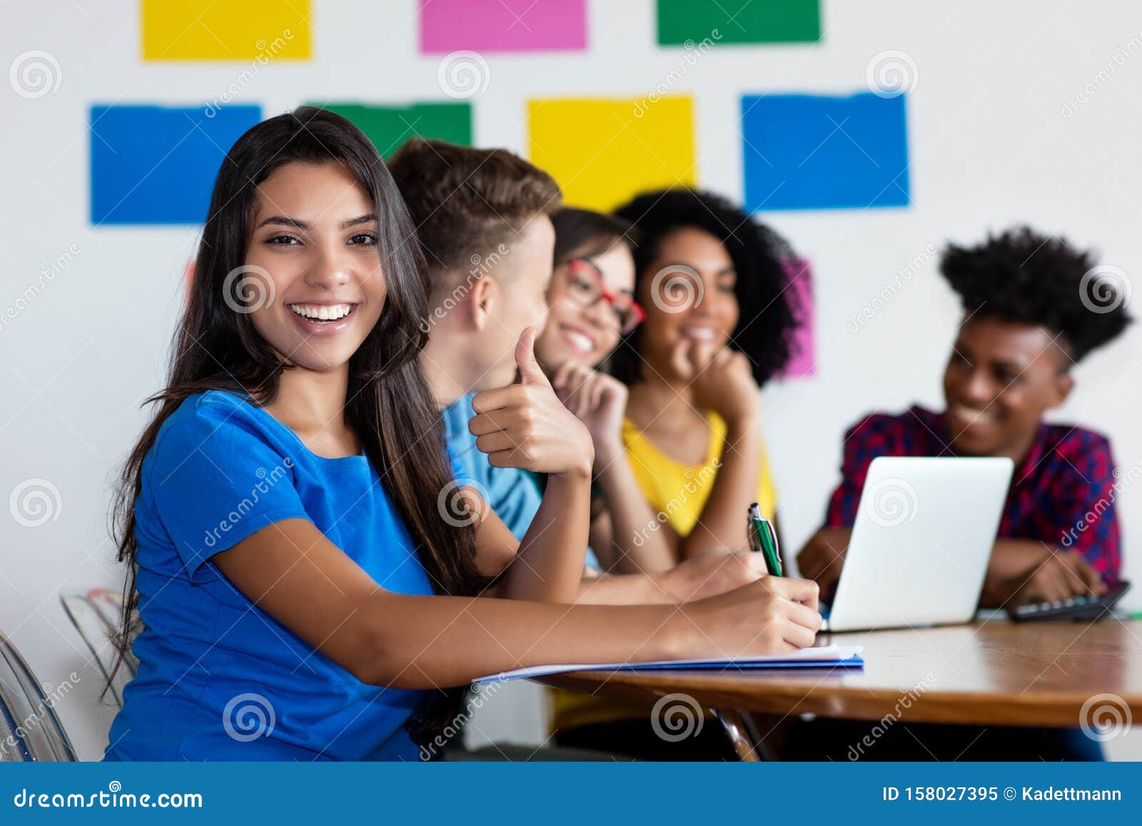 Beautiful Hispanic Female Student Learning with Group of Students Stock ...