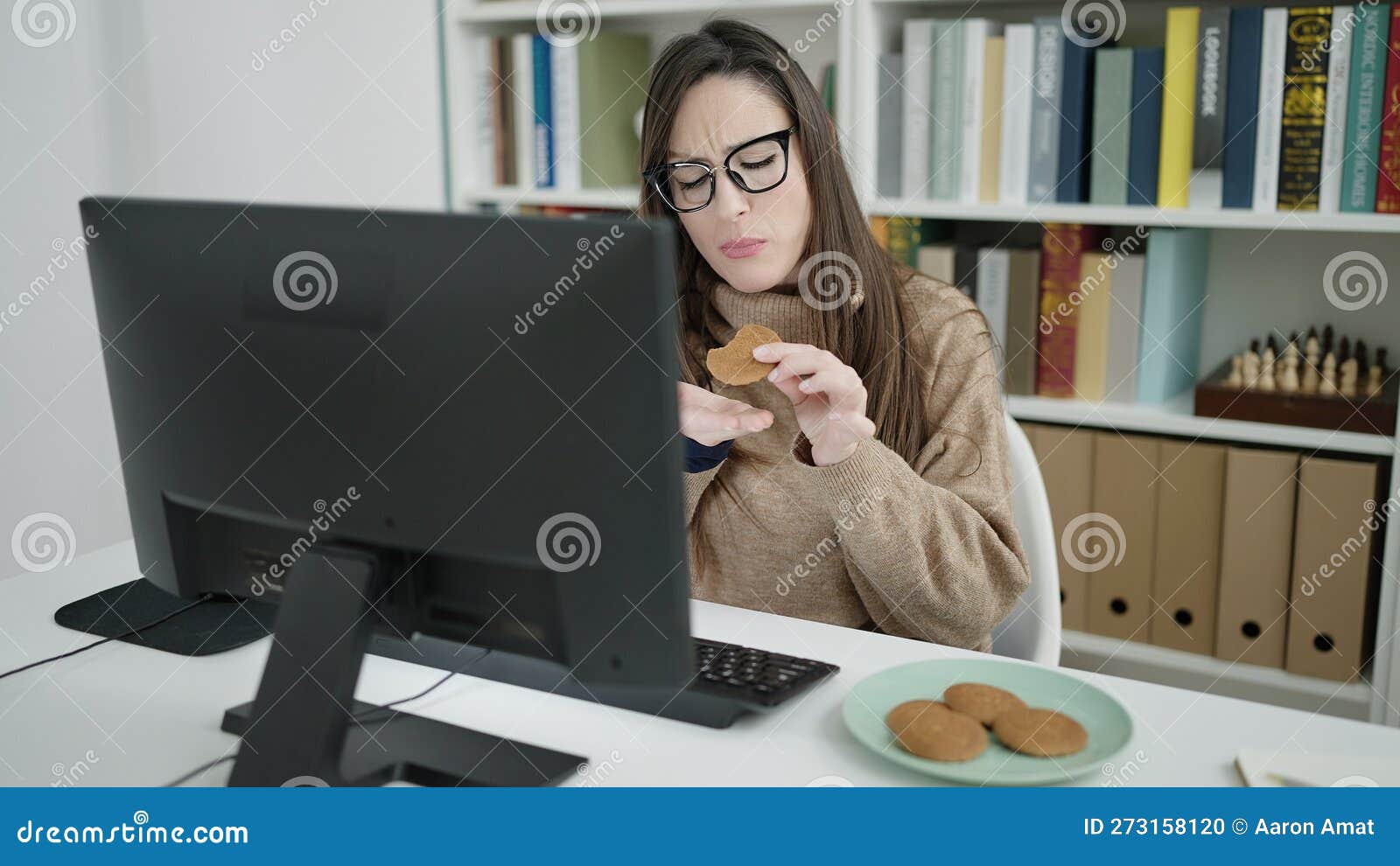 Beautiful Hispanic Woman Student Using Computer Eating Cookies at ...
