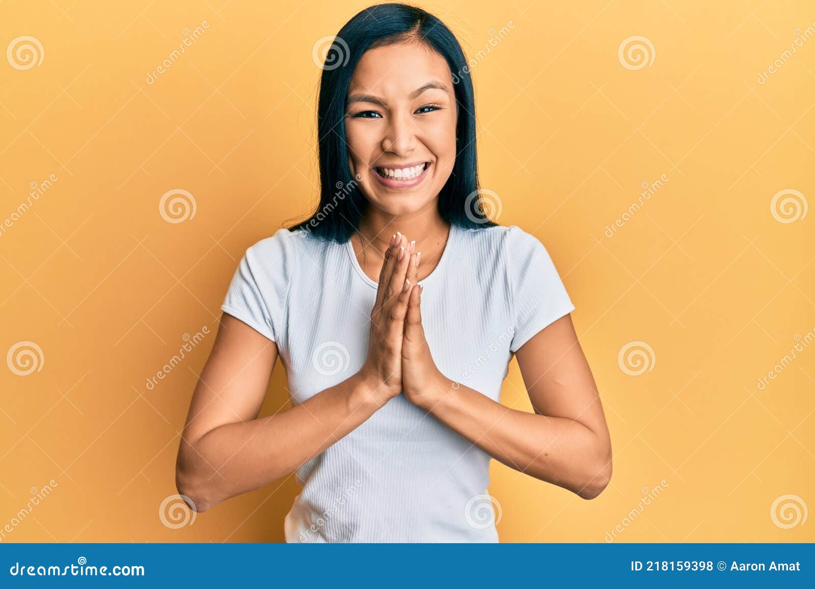 Beautiful Hispanic Woman Wearing Casual White Tshirt Praying With Hands