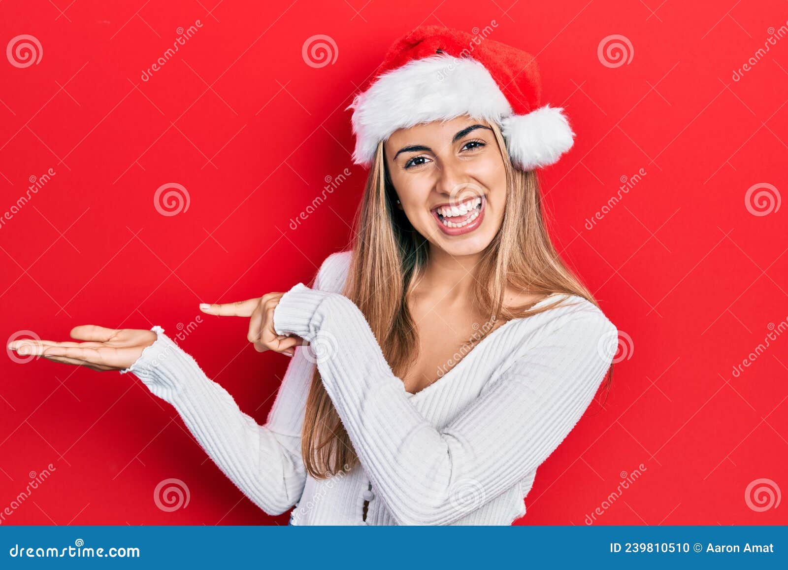 Beautiful Hispanic Woman Wearing Christmas Hat Amazed And Smiling To