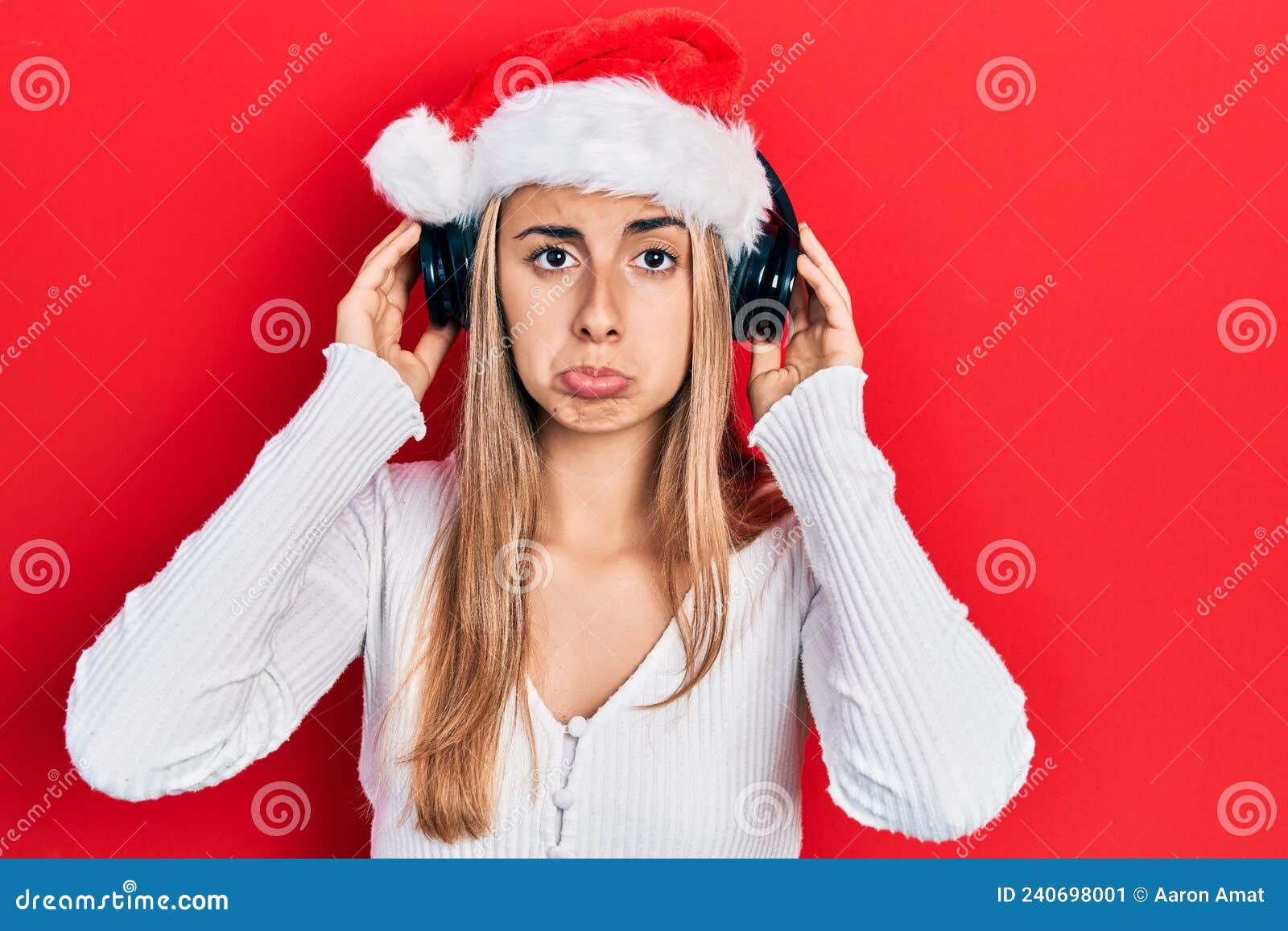 Beautiful Hispanic Woman Wearing Christmas Hat And Headphones Depressed