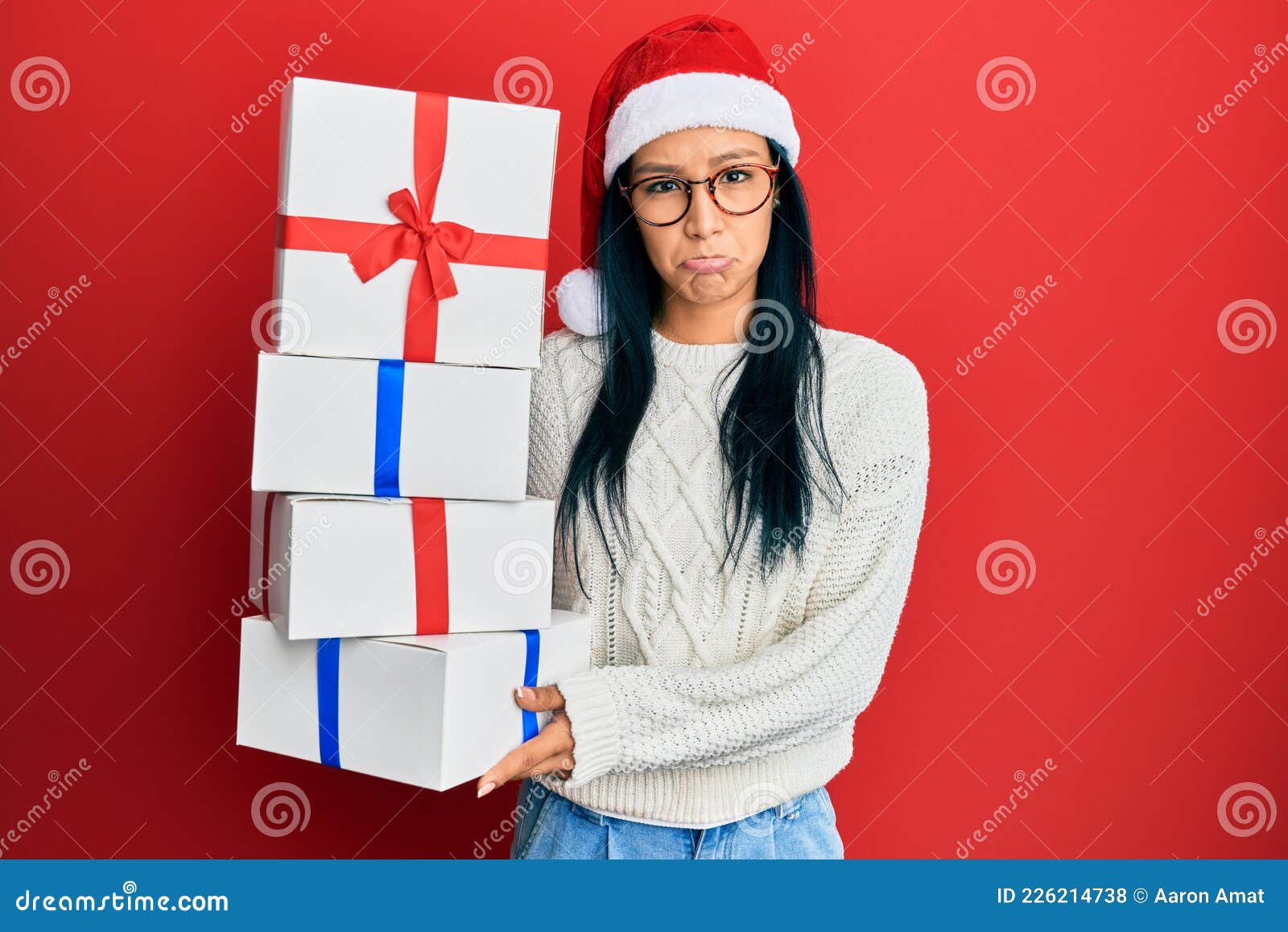 Beautiful Hispanic Woman Wearing Christmas Hat And Holding Ts