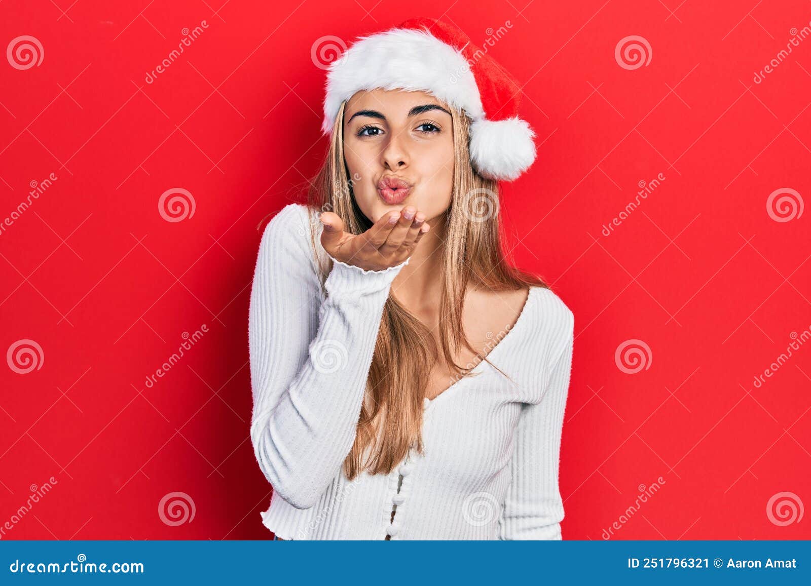 Beautiful Hispanic Woman Wearing Christmas Hat Looking At The Camera