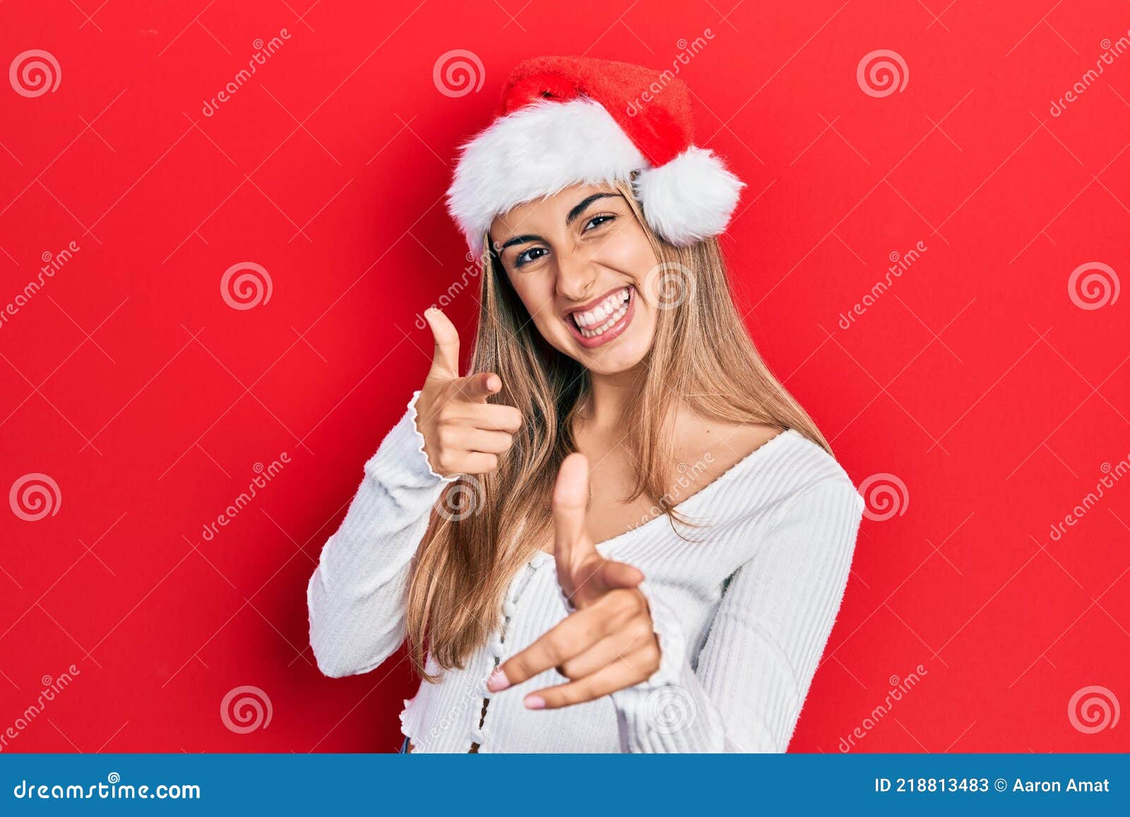 Beautiful Hispanic Woman Wearing Christmas Hat Pointing Fingers To