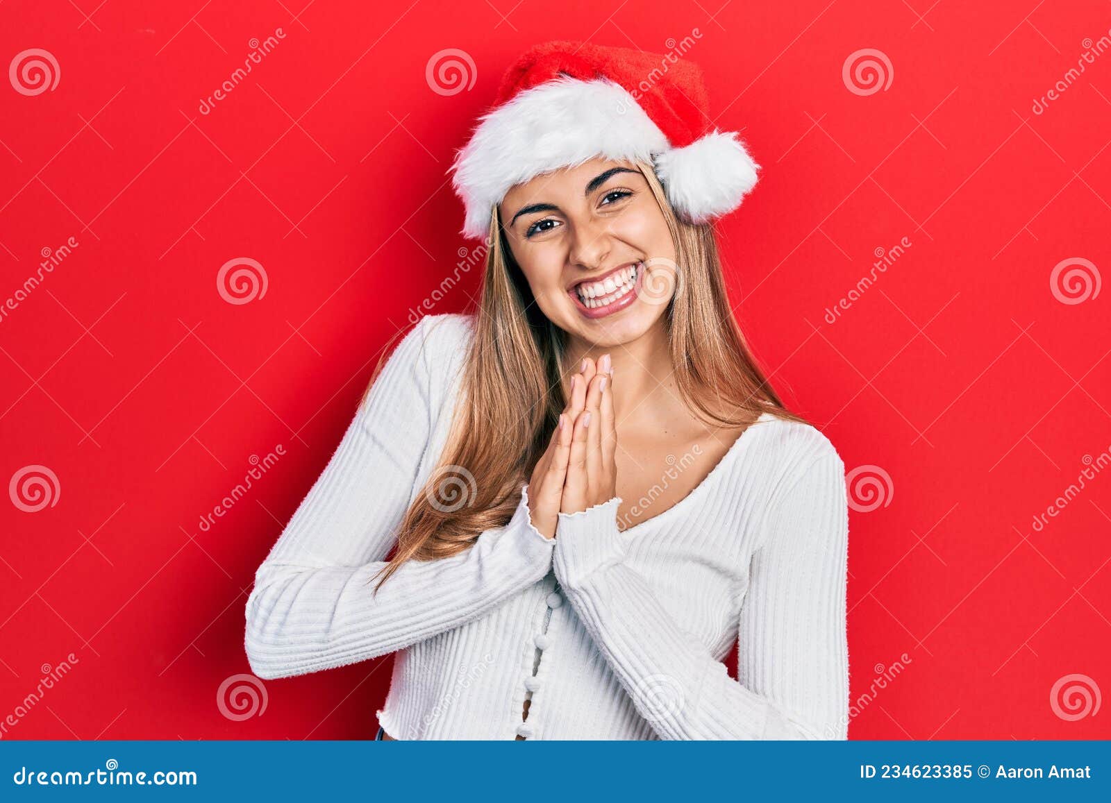 Beautiful Hispanic Woman Wearing Christmas Hat Praying With Hands