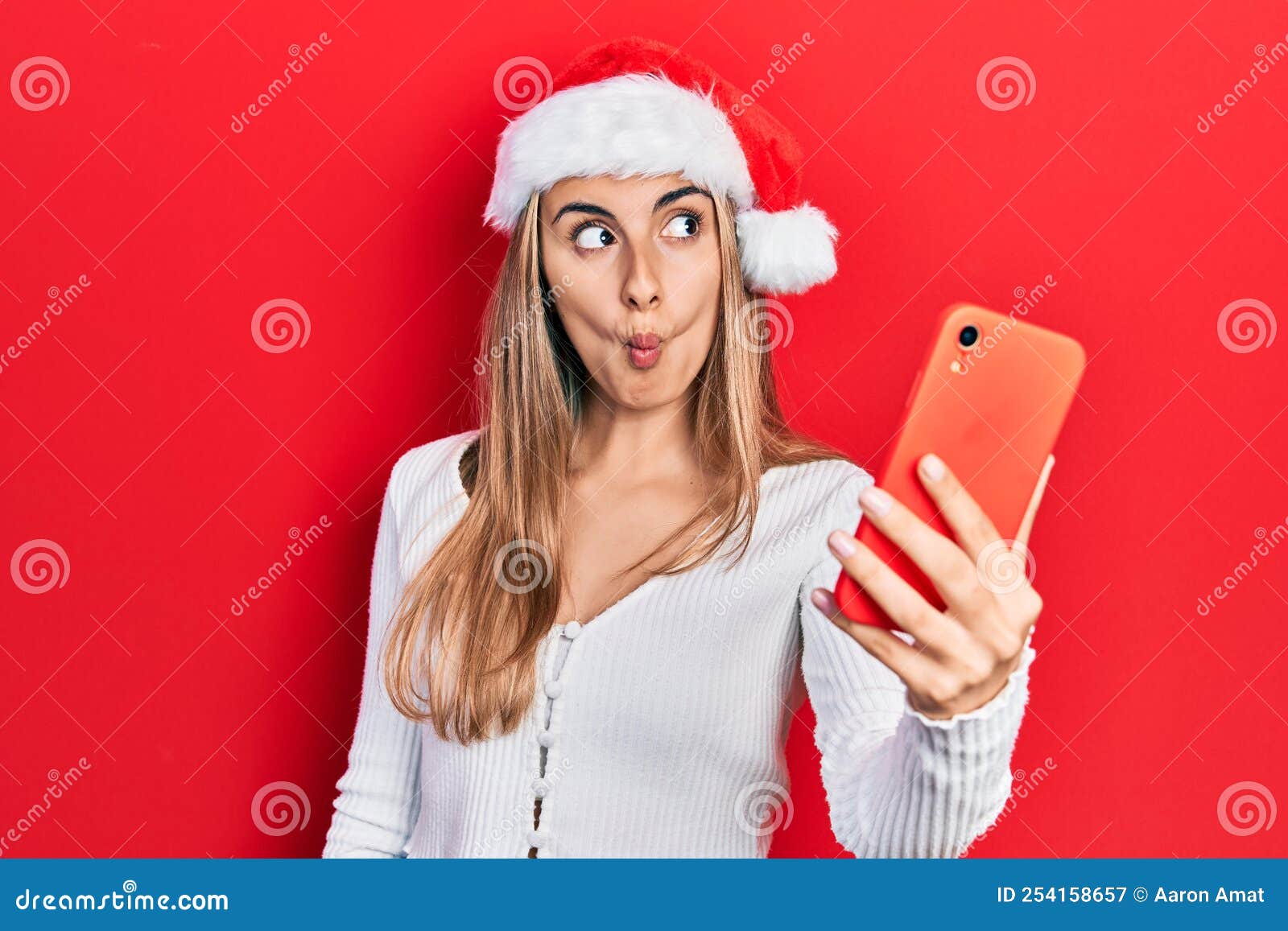 Beautiful Hispanic Woman Wearing Christmas Hat Using Smartphone Making
