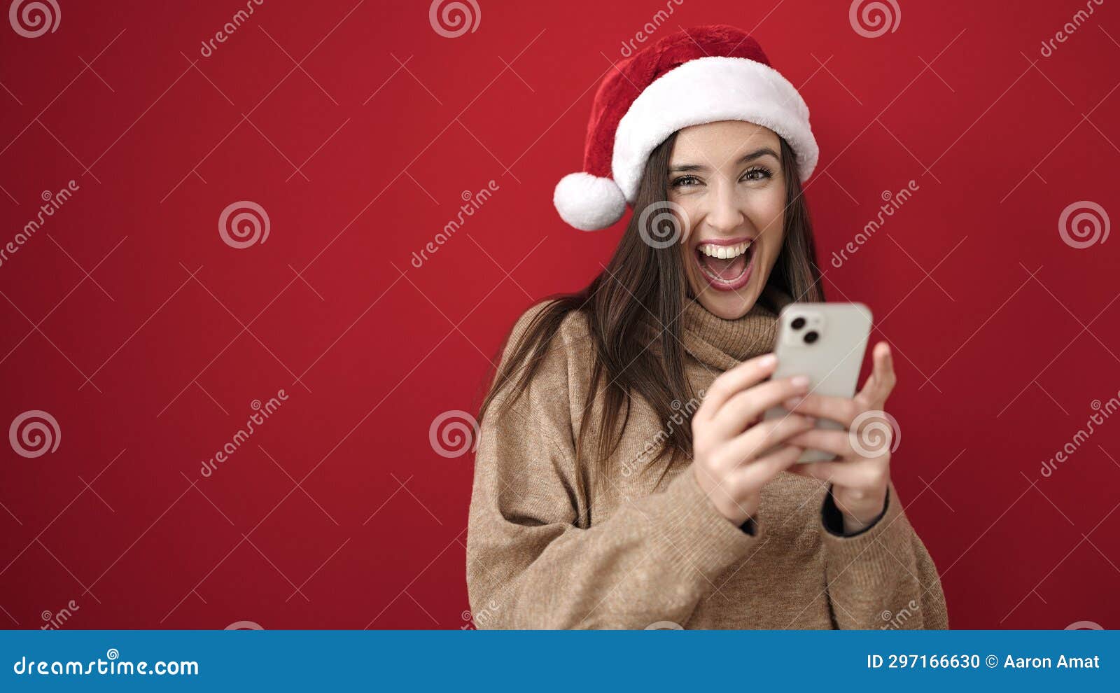 Beautiful Hispanic Woman Wearing Christmas Hat Using Smartphone Over