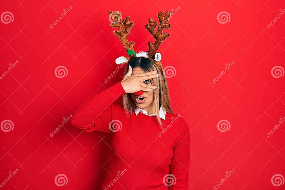Beautiful Hispanic Woman Wearing Deer Christmas Hat And Red Nose