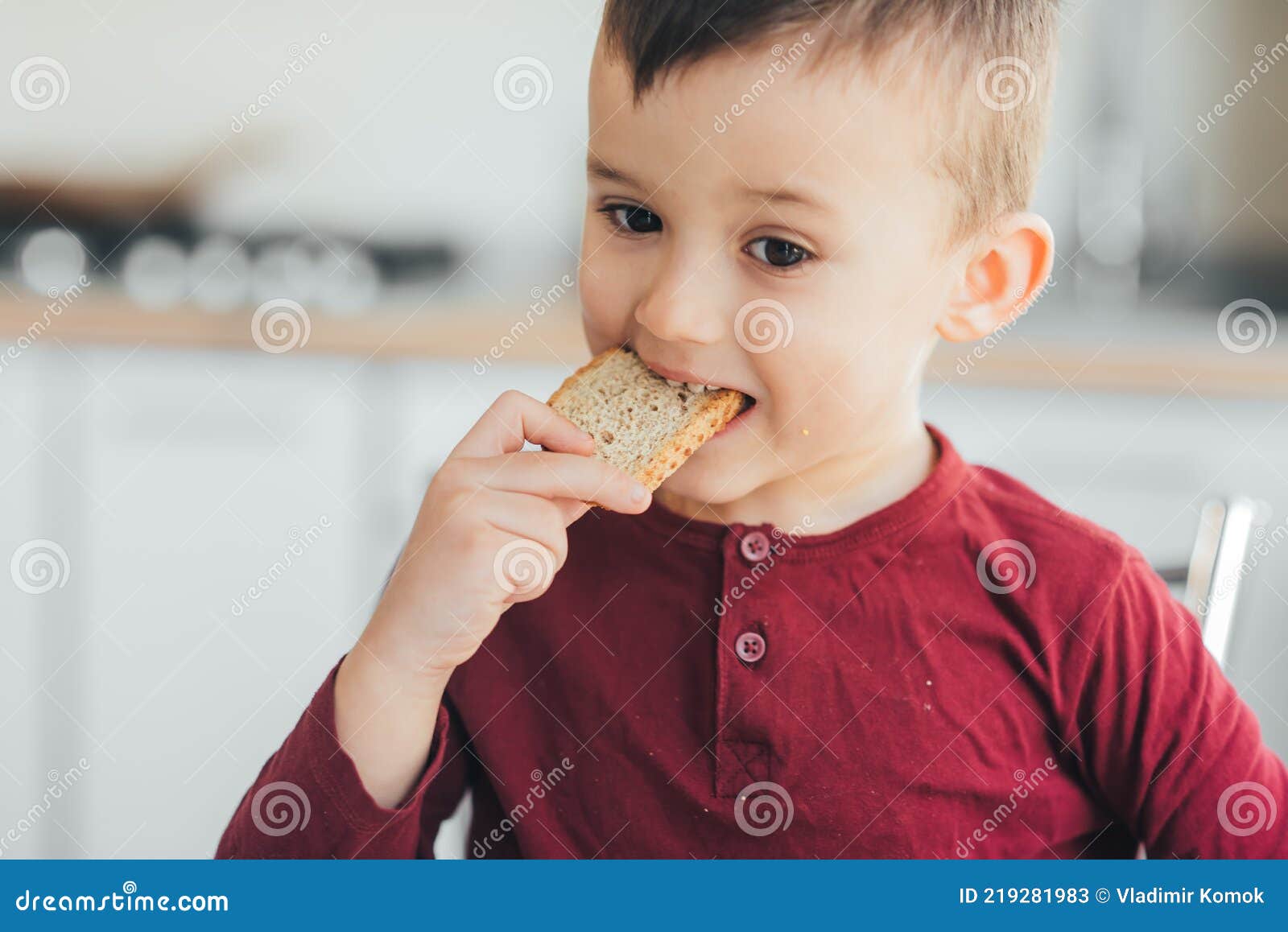 Beautiful Little Boy in the Kitchen Eating a Piece of Bread, Hungry ...