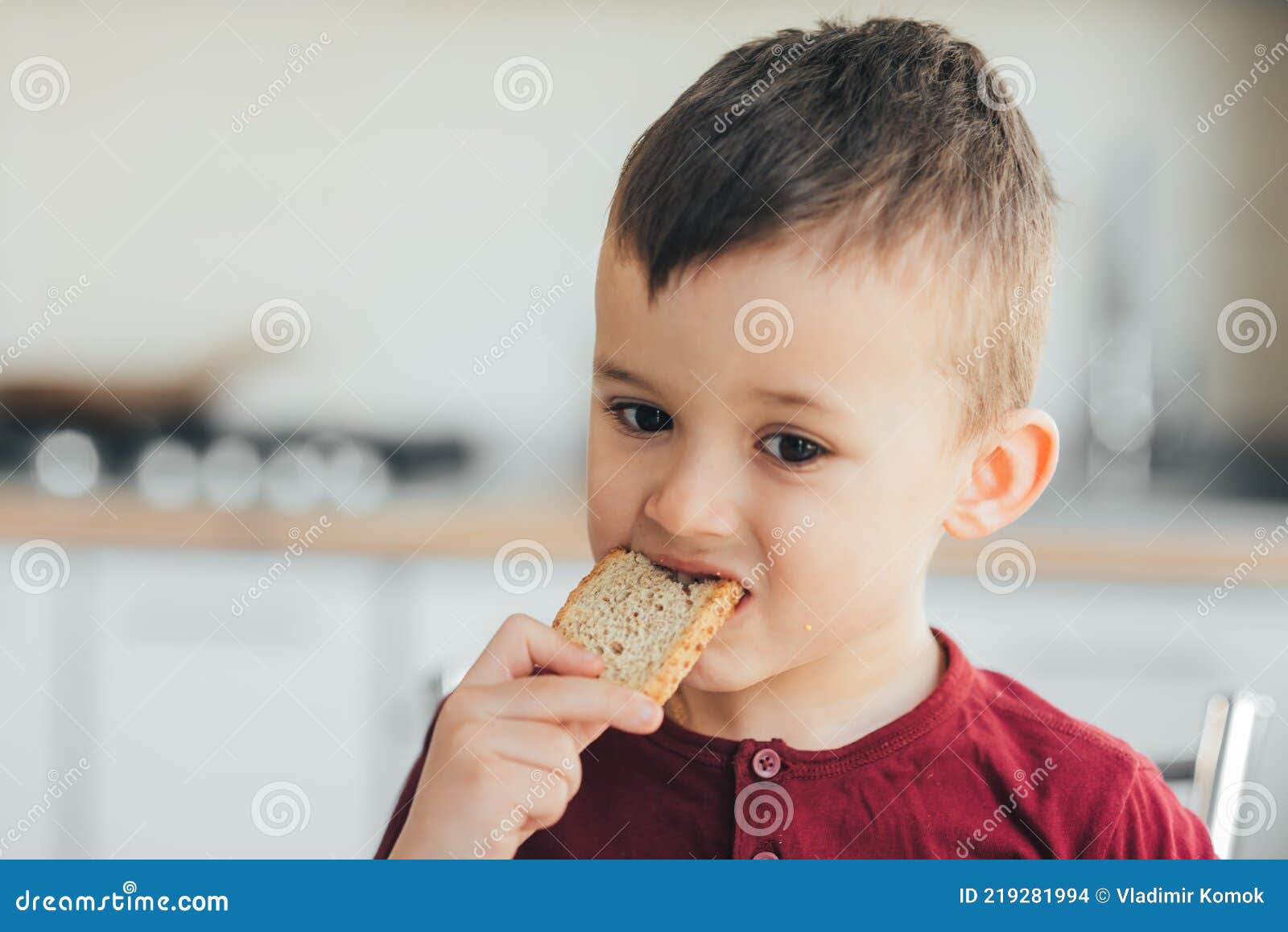 Beautiful Little Boy in the Kitchen Eating a Piece of Bread, Hungry ...