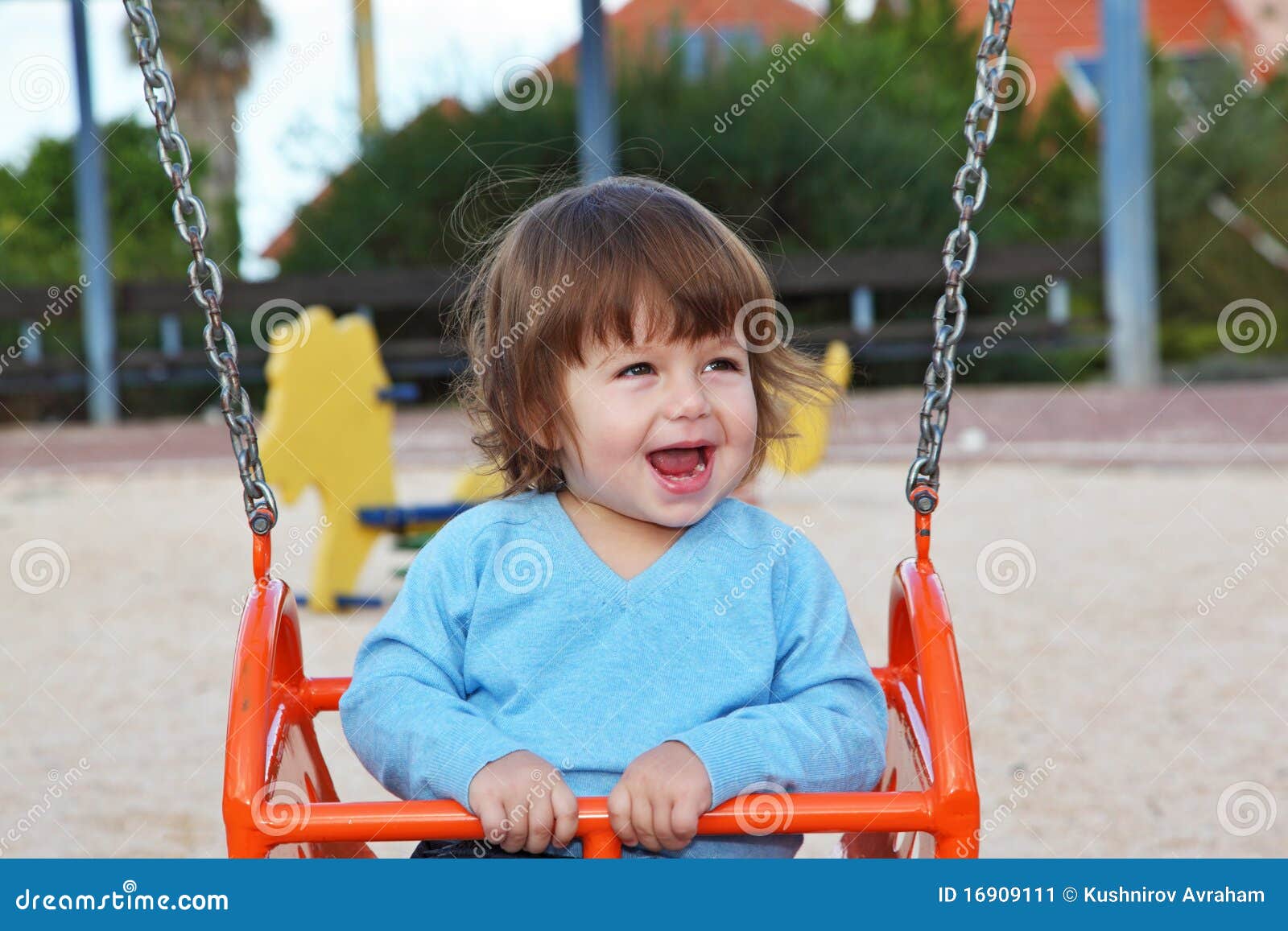 The Beautiful Little Boy Laughs at a Red Swing Stock Image - Image of ...