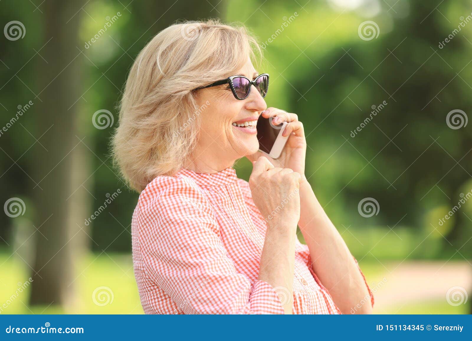 Beautiful Mature Woman Talking On Mobile Phone Outdoors Stock Image
