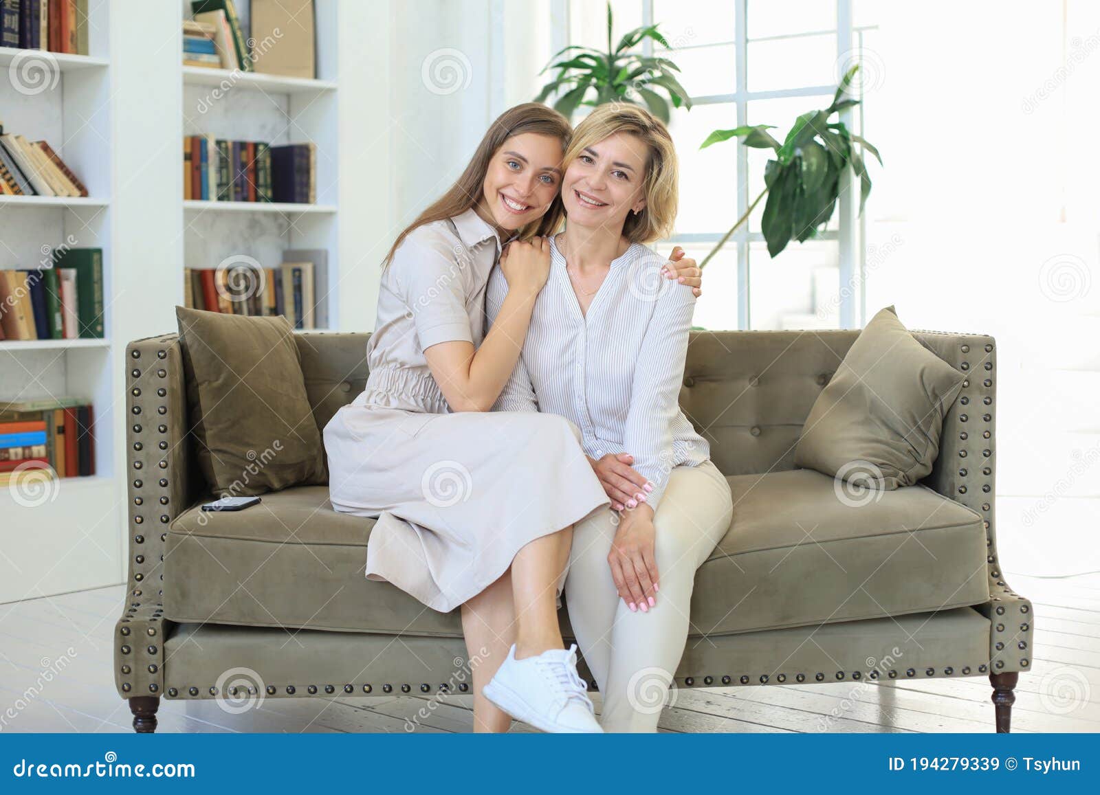 Beautiful Middle Aged Mom And Her Adult Daughter Are Hugging Looking