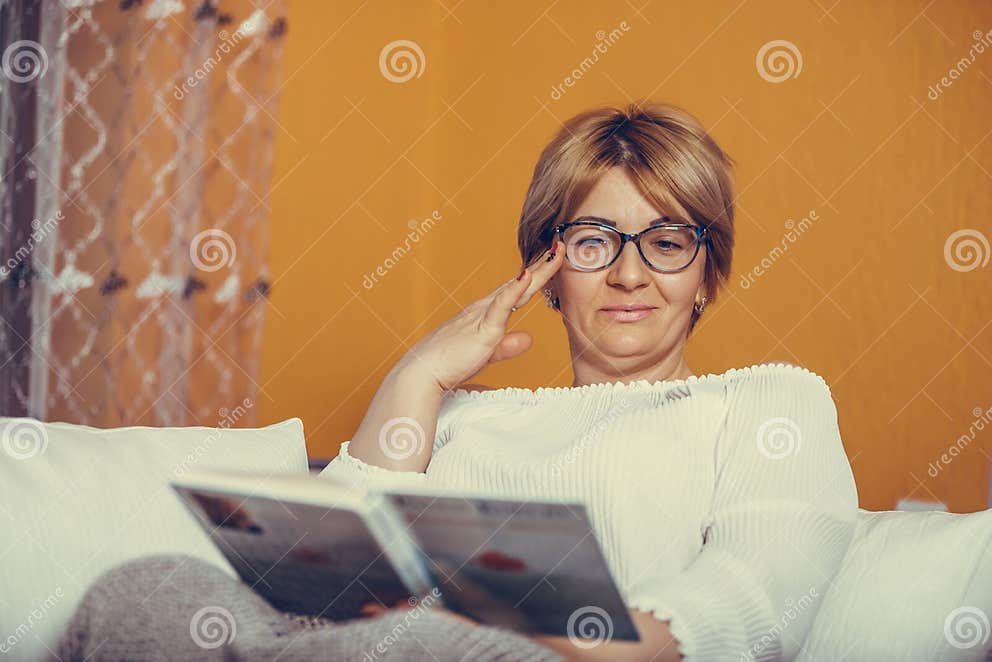 Beautiful Middle Aged Woman In Glasses Reading Book And Enjoy While