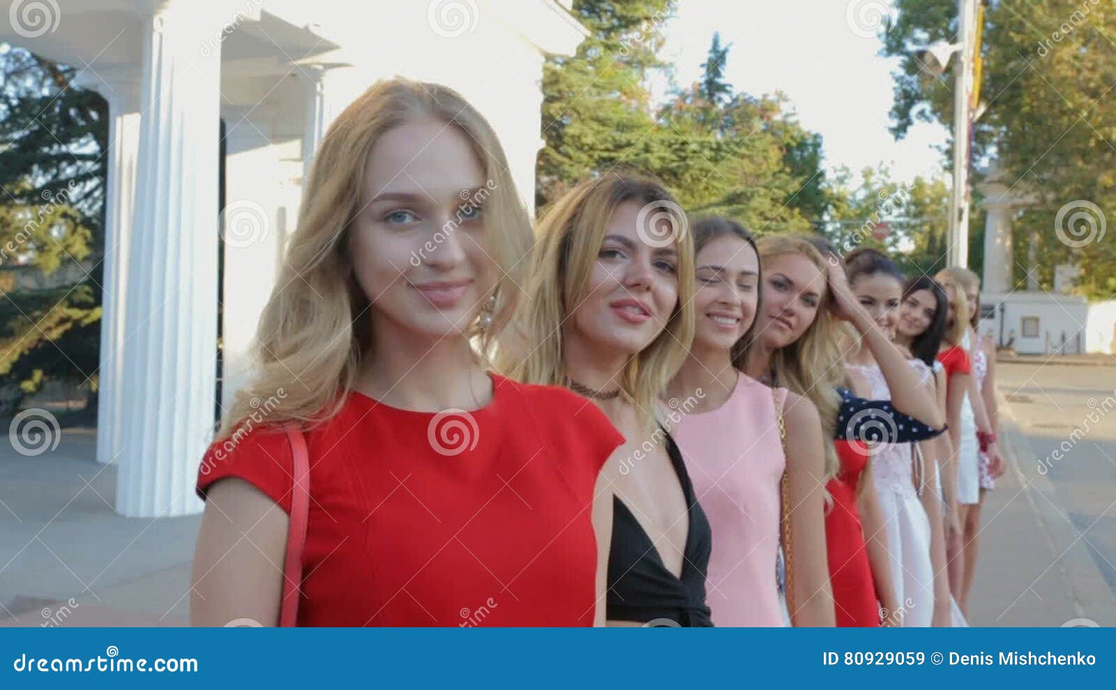 Beautiful Models in Dresses Standing in a Row on the Street and Posing ...