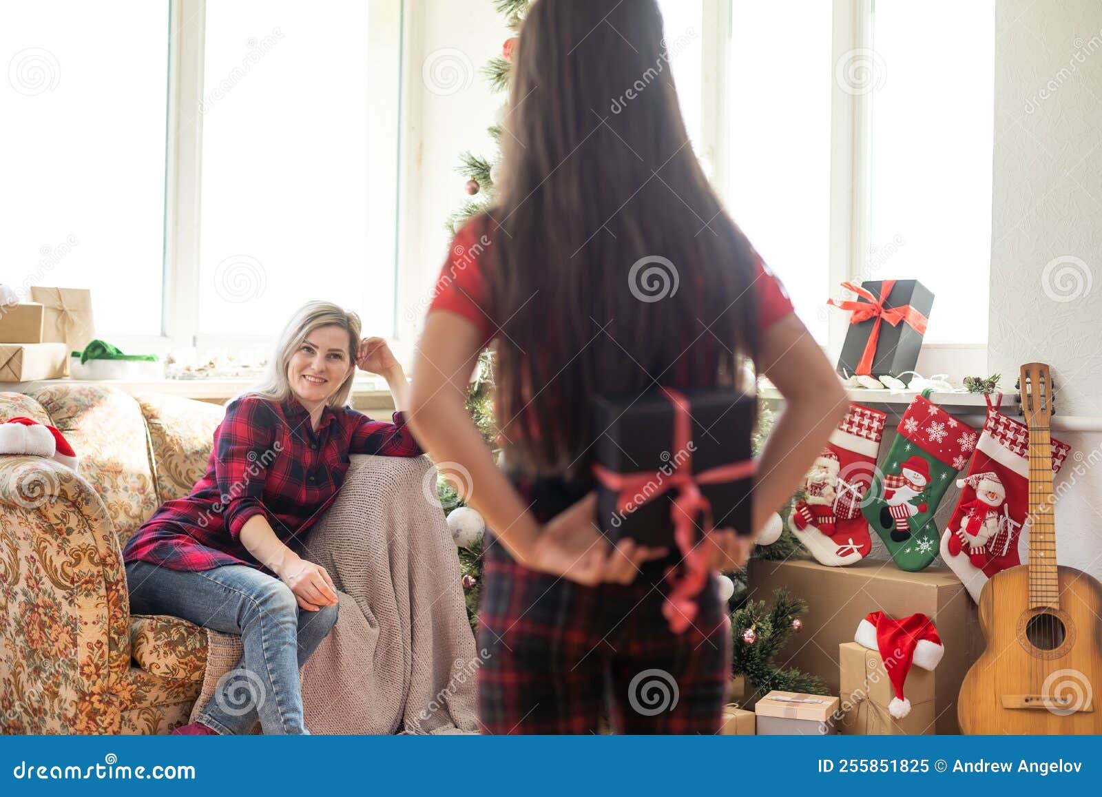 Beautiful Mother And Daughter Sitting By Nicely Decorated Christmas