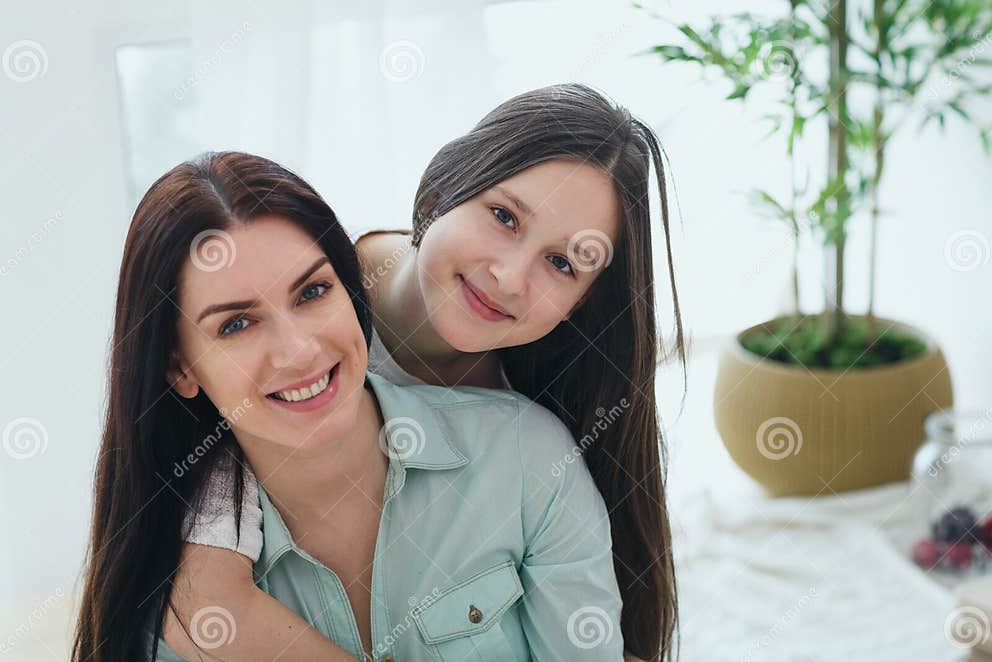 Beautiful Mother And Her Cute Daughter Smiling And Posing At Home