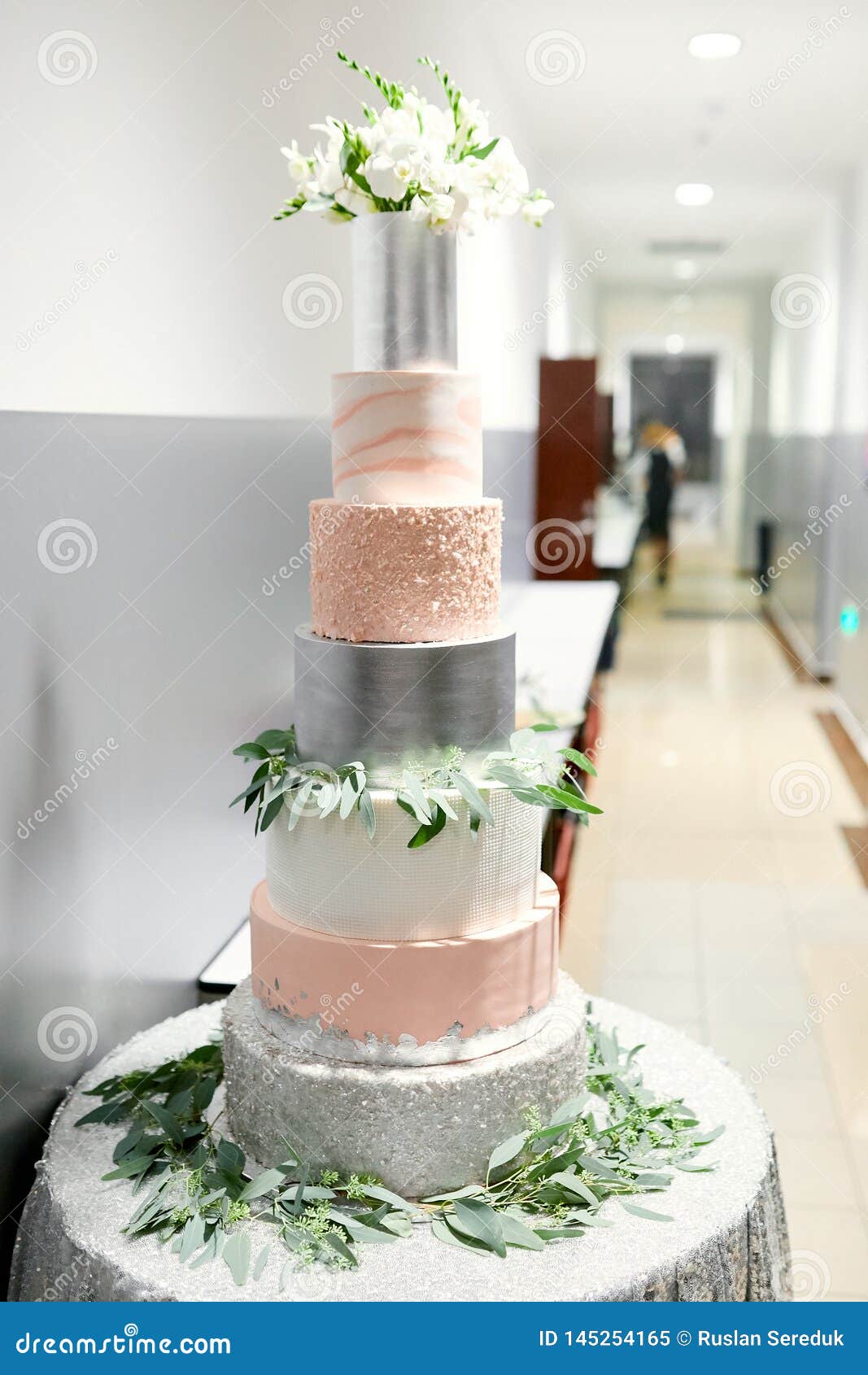 Beautiful Multi-level Cake with Greens on a Silver Tablecloth on the ...