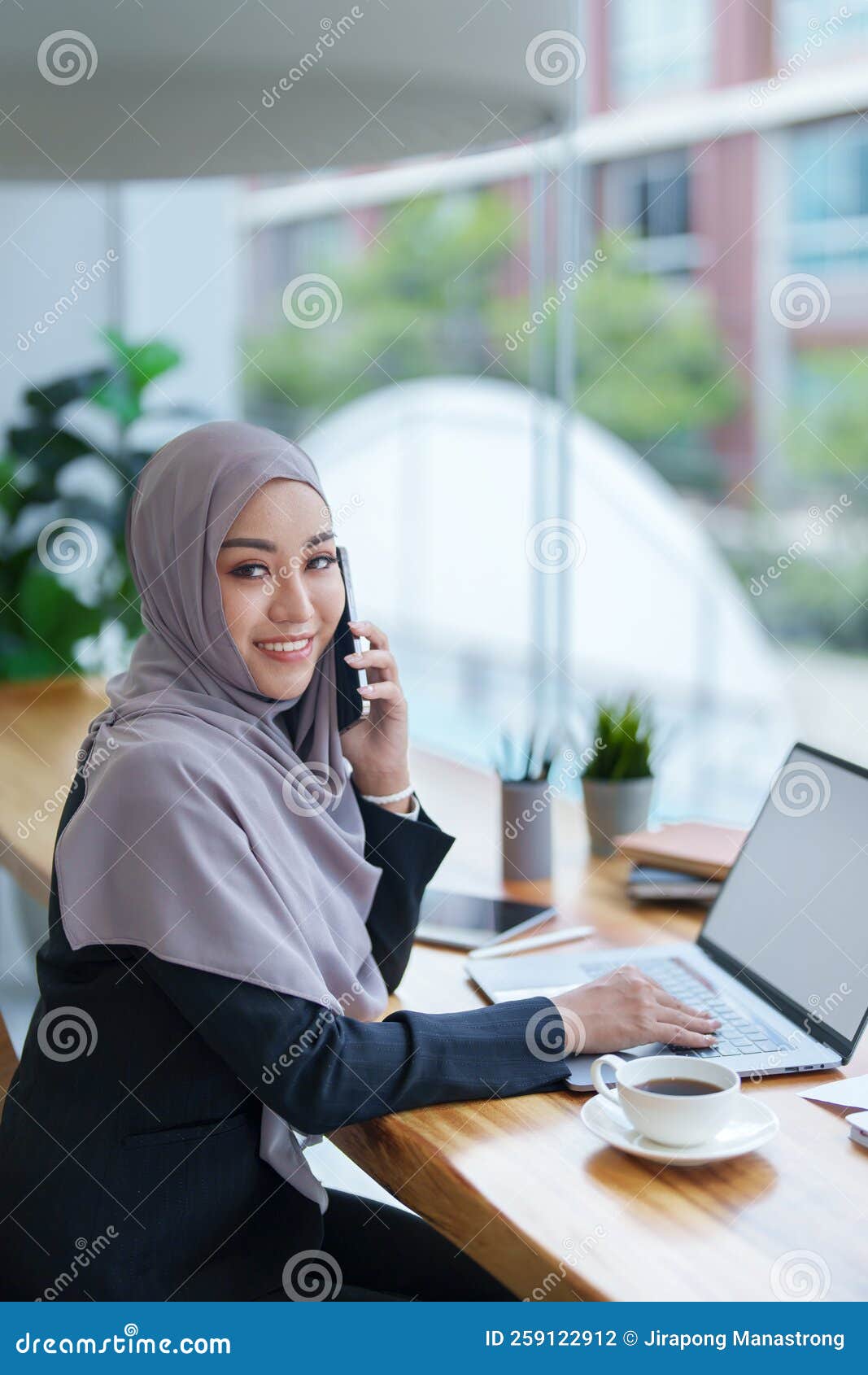 Beautiful Muslim Woman Talking on the Phone and Using Computer on Top ...