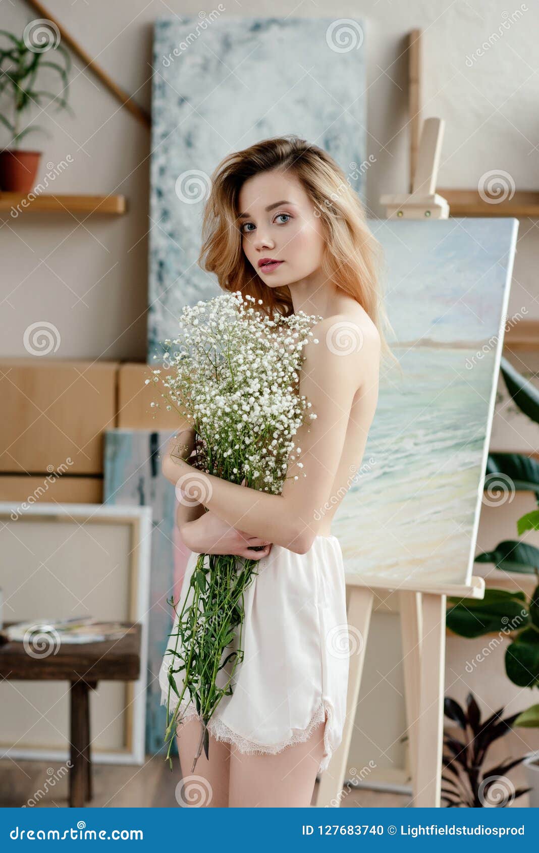 Beautiful Naked Young Woman Holding White Flowers and Looking at Camera ... Beautiful Naked Young Woman Holding White Flowers and Looking at Camera ...