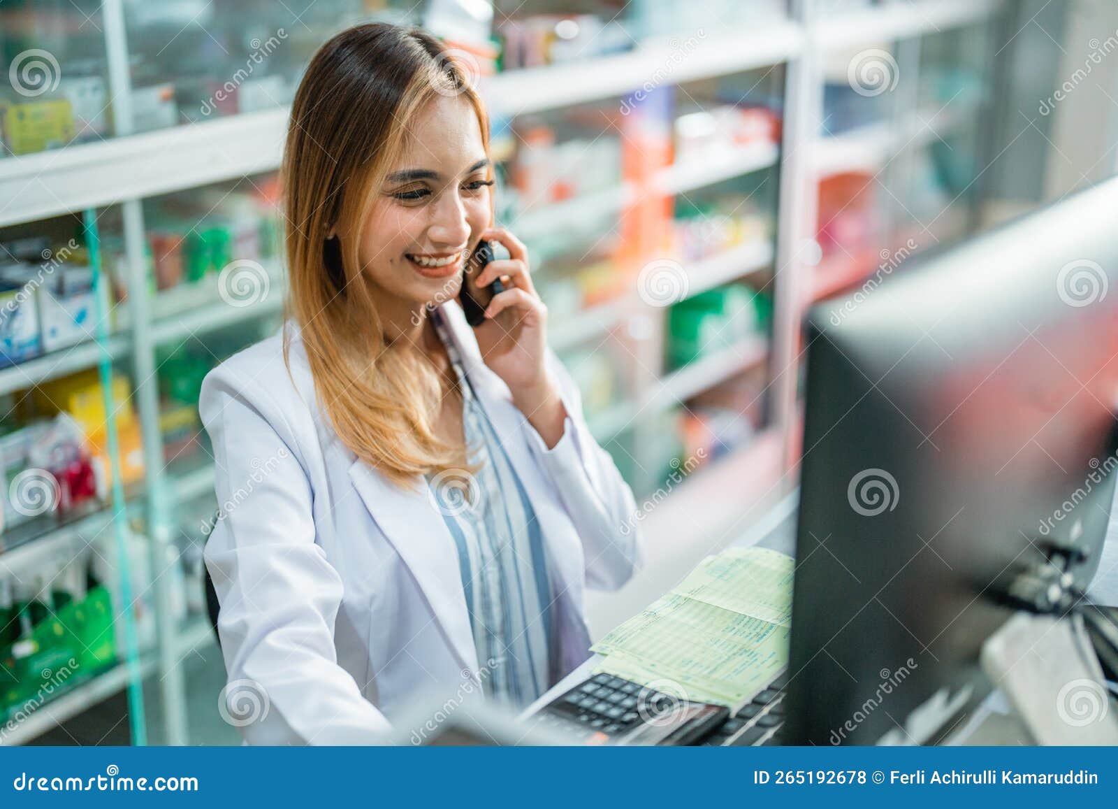 Beautiful Pharmacist Working in Front of Computer Monitor while Calling ...