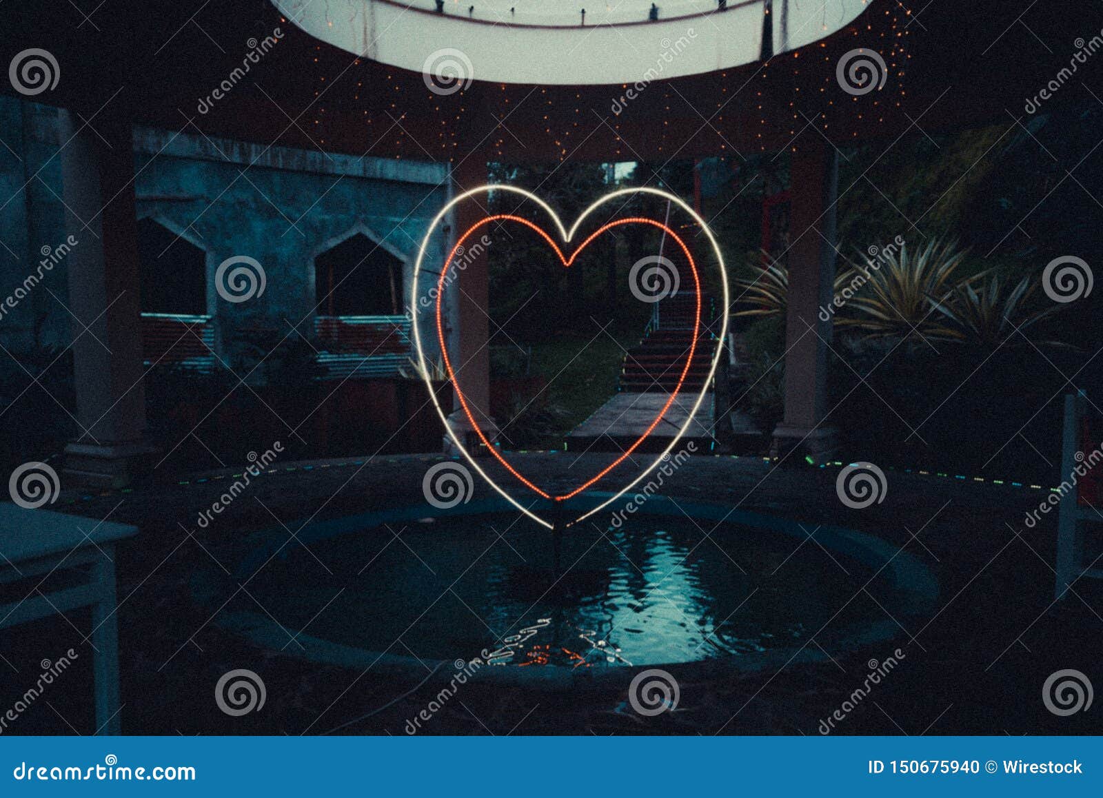 Beautiful Pool in a Park with a Neon Heart with Reflection Above the ...