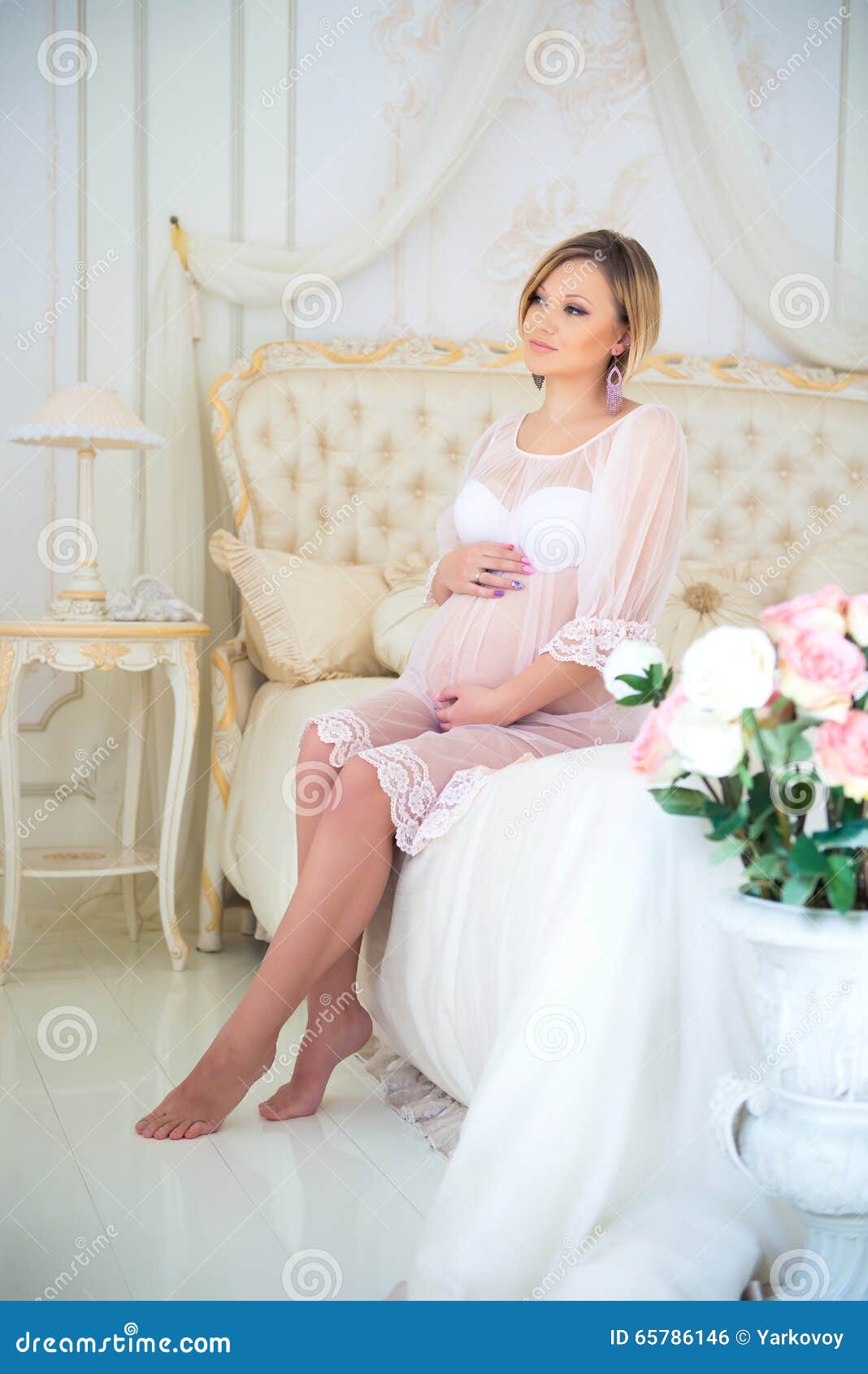 Beautiful Pregnant Girl In A Home Clothes Sitting In The Interior On A