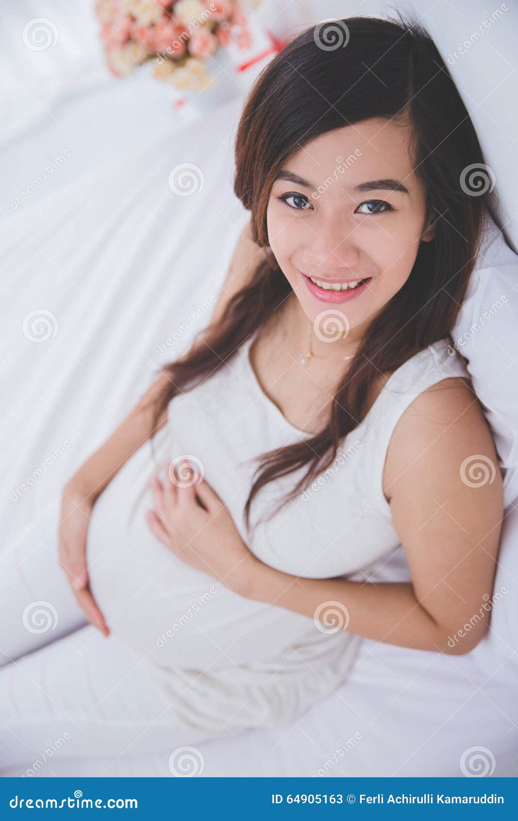 Beautiful Pregnant Woman Smiling In To Camera While Lying On The Stock