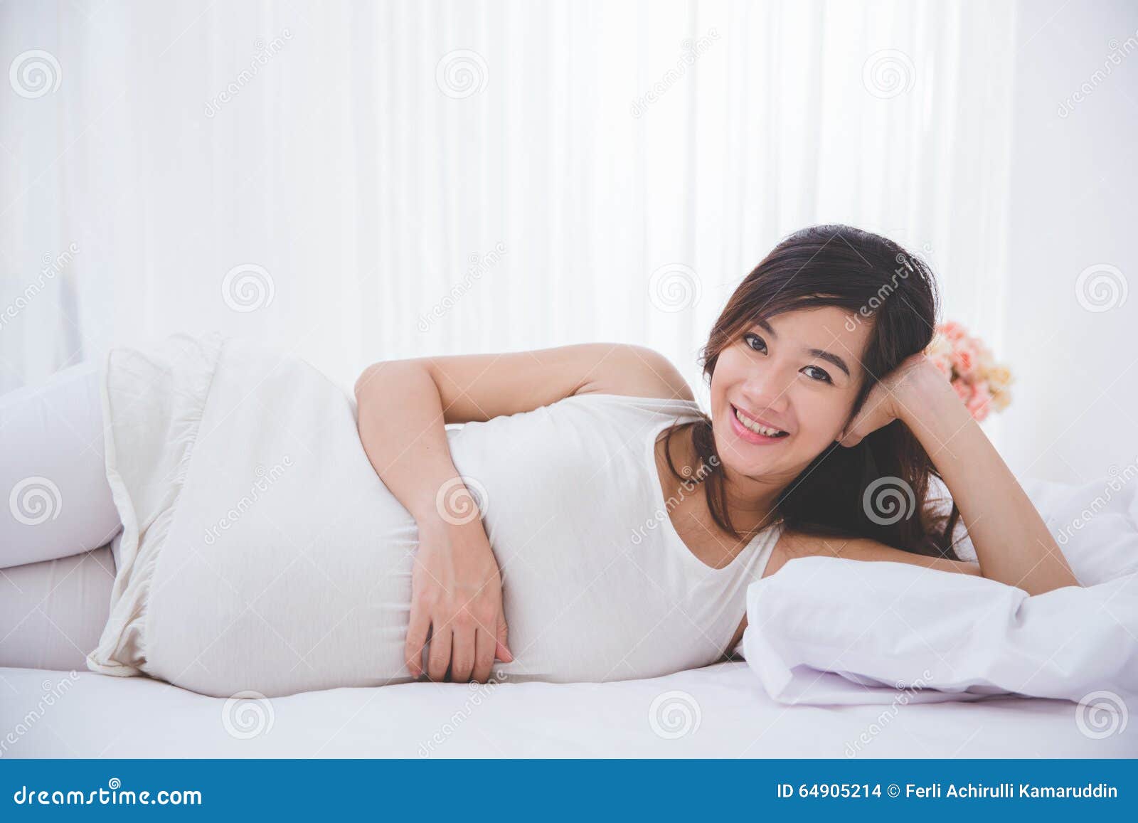 Beautiful Pregnant Woman Smiling In To Camera While Lying On The Stock