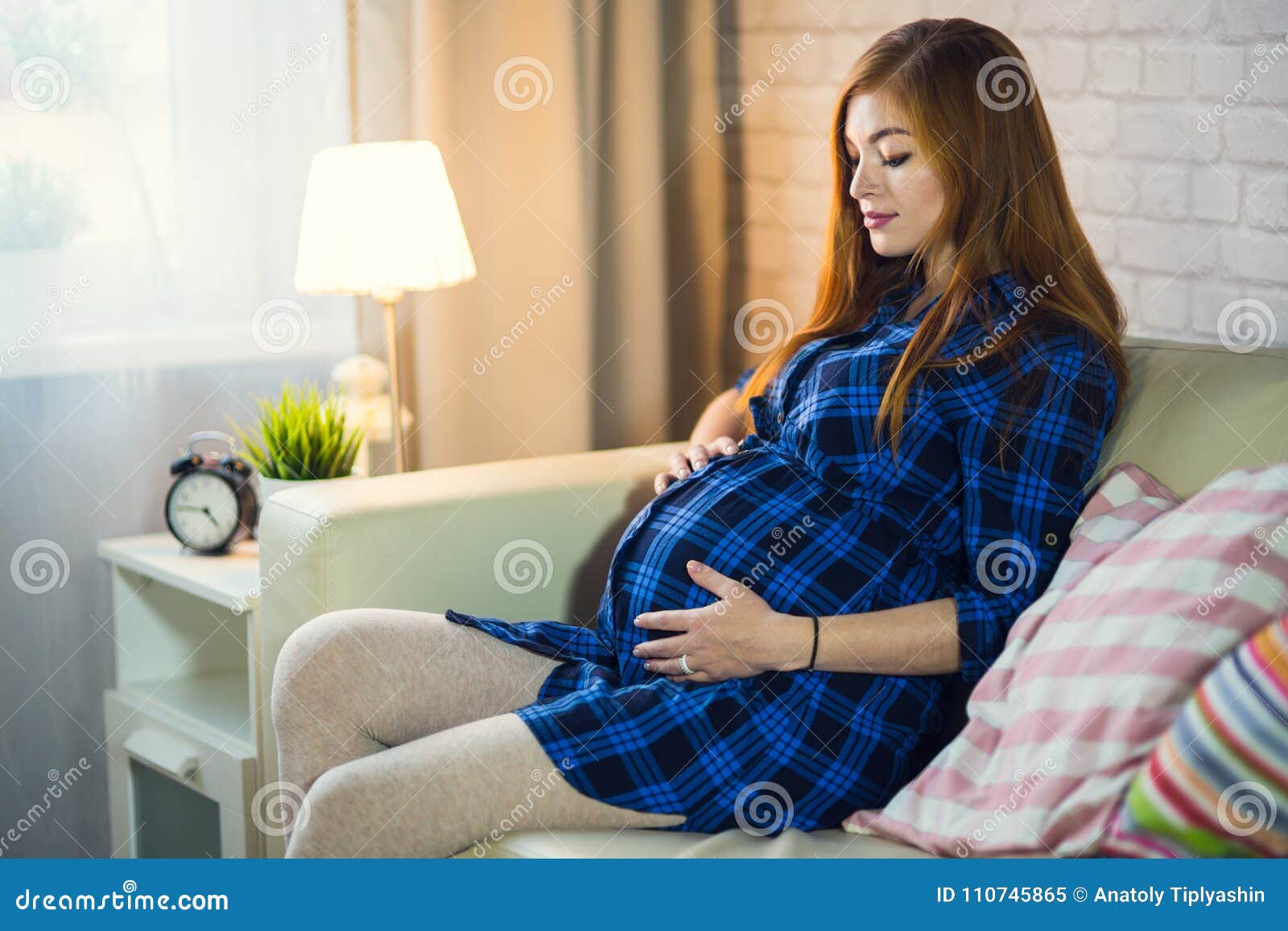 Beautiful Red Haired Young Pregnant Woman Sitting At Home On The Stock
