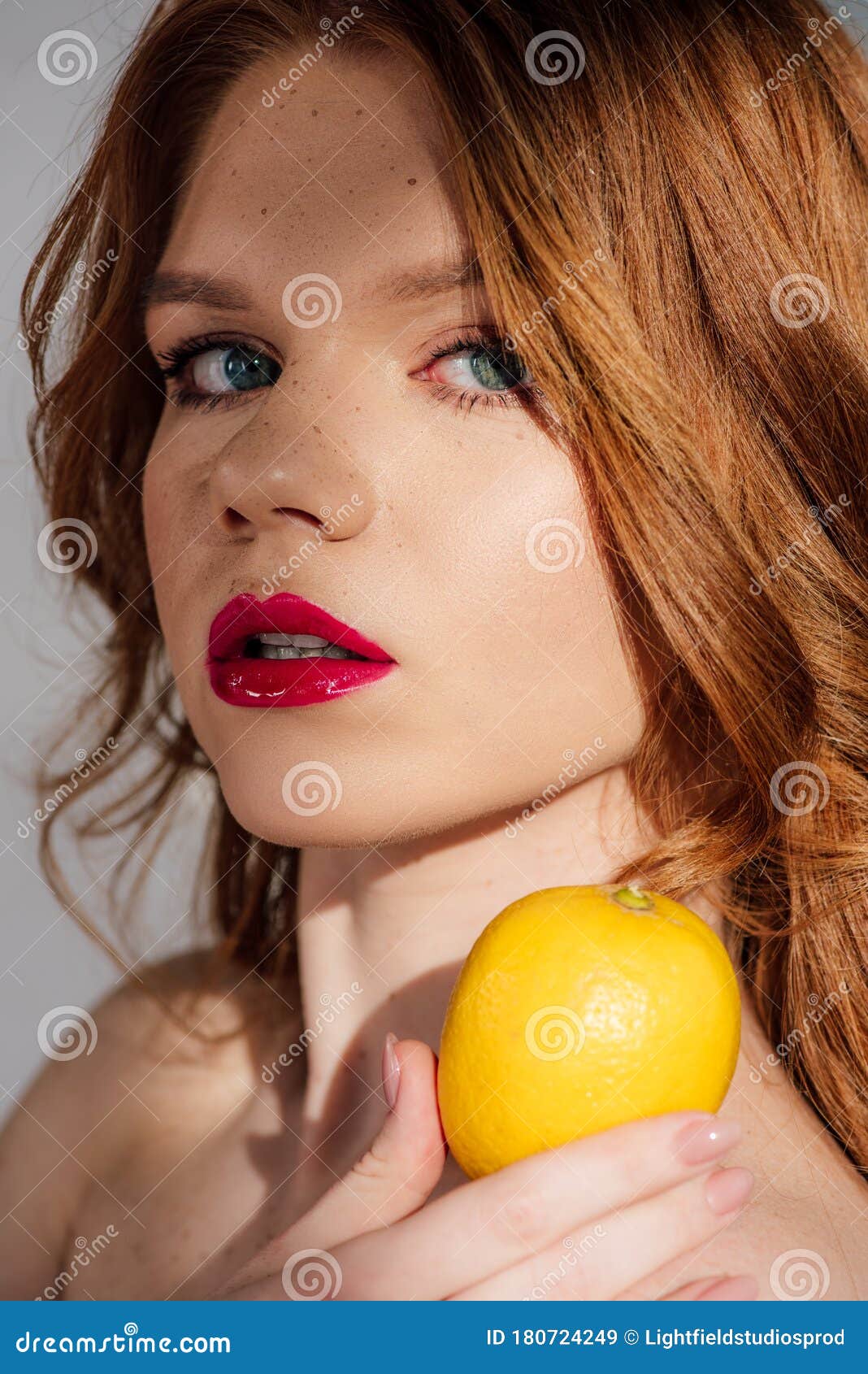 Beautiful Redhead Girl With Red Lips Holding Lemon And Posing Isolated